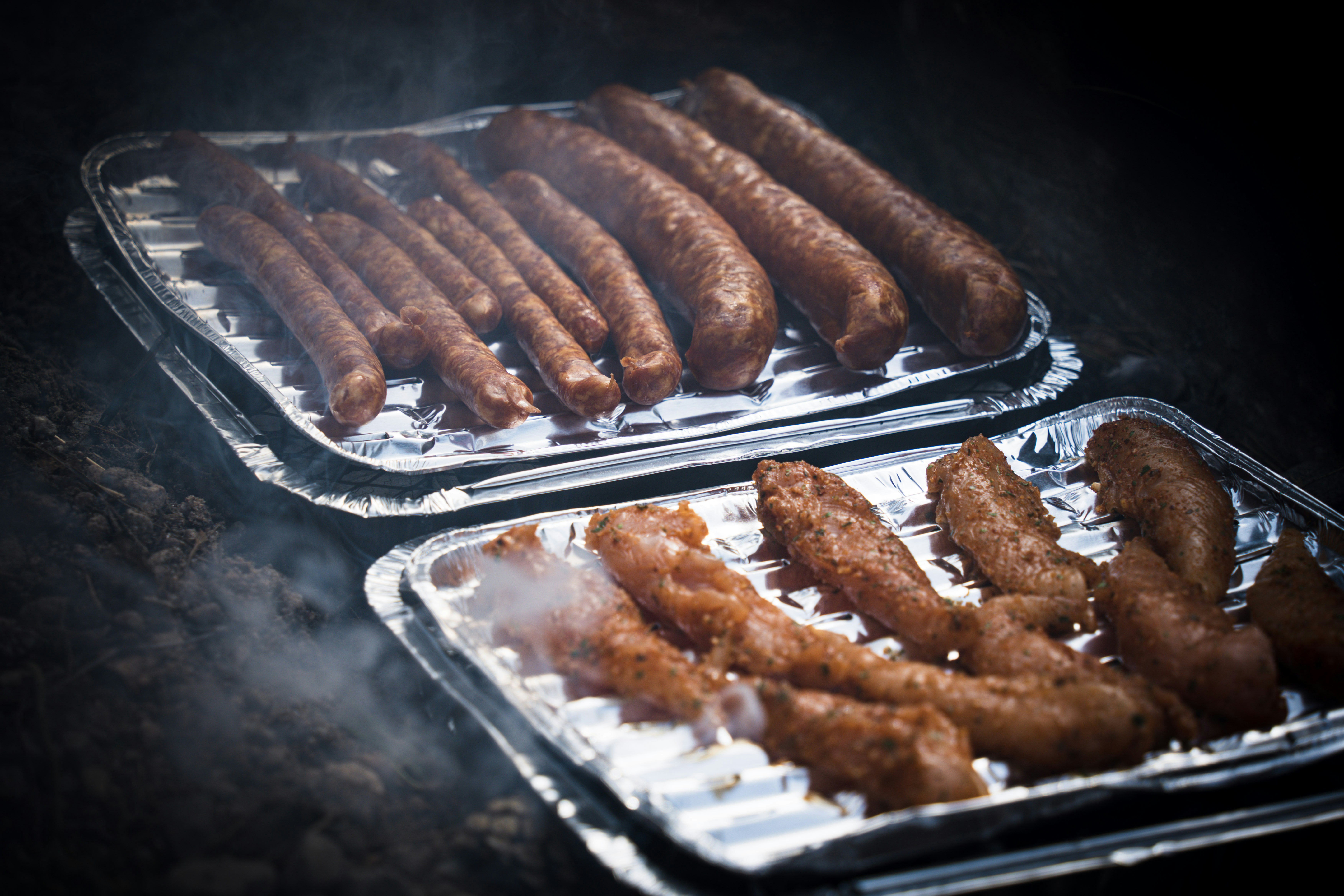 Charred Snakes: Smoky Sausages Grilling in Aluminum Trays