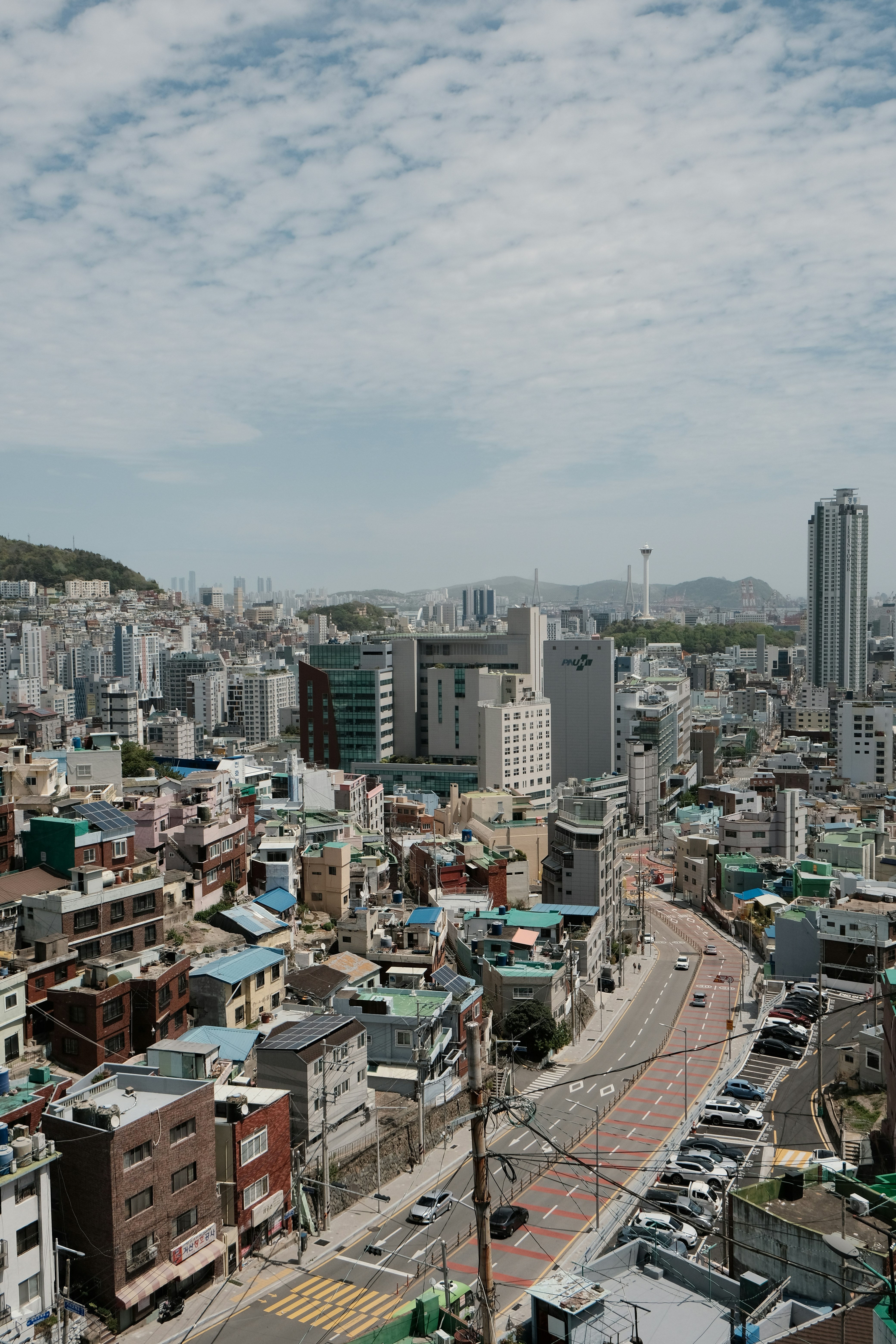A dense cityscape with varied buildings and a road.