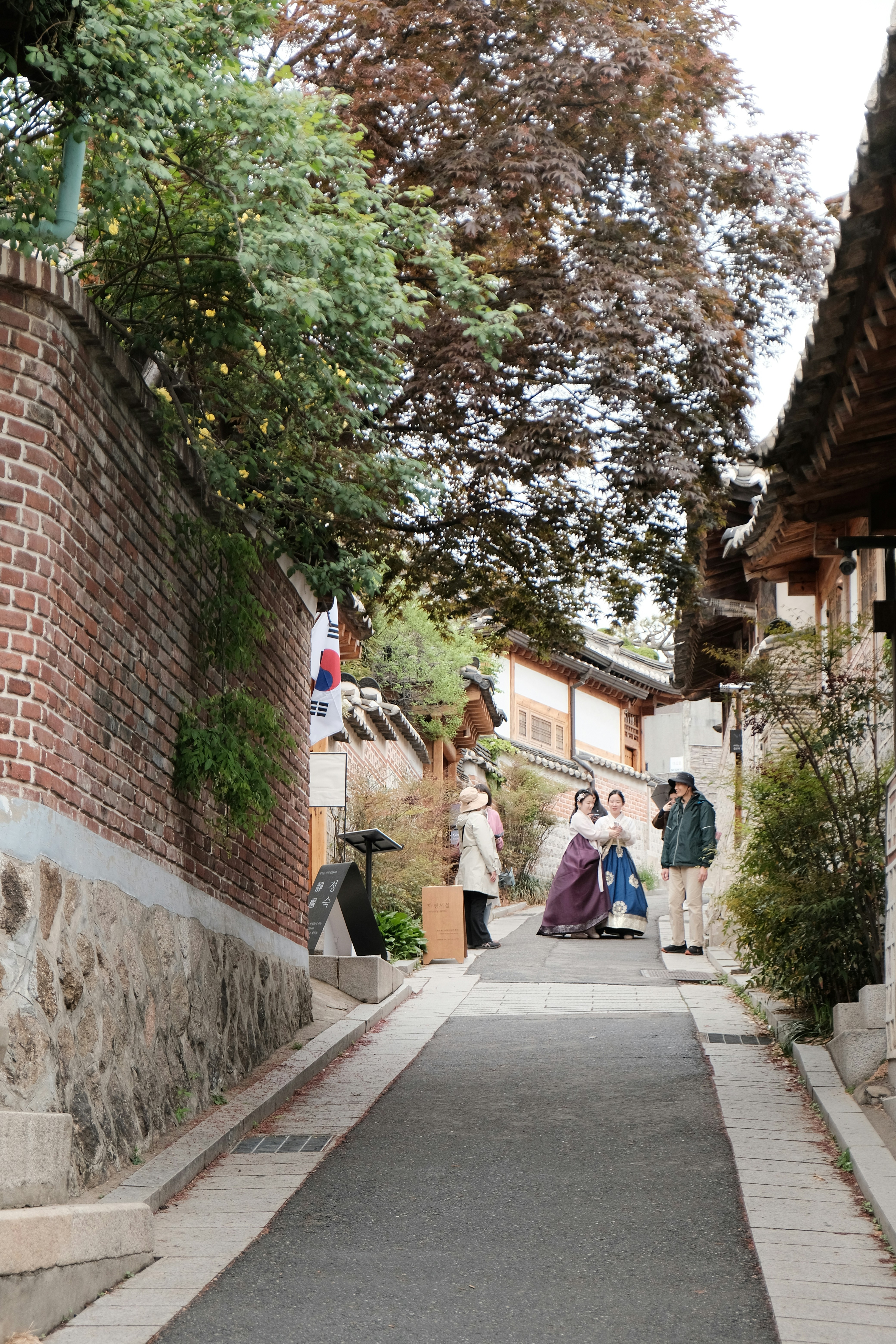 Courtyard of Echoes: Travelers in a Traditional Korean Street