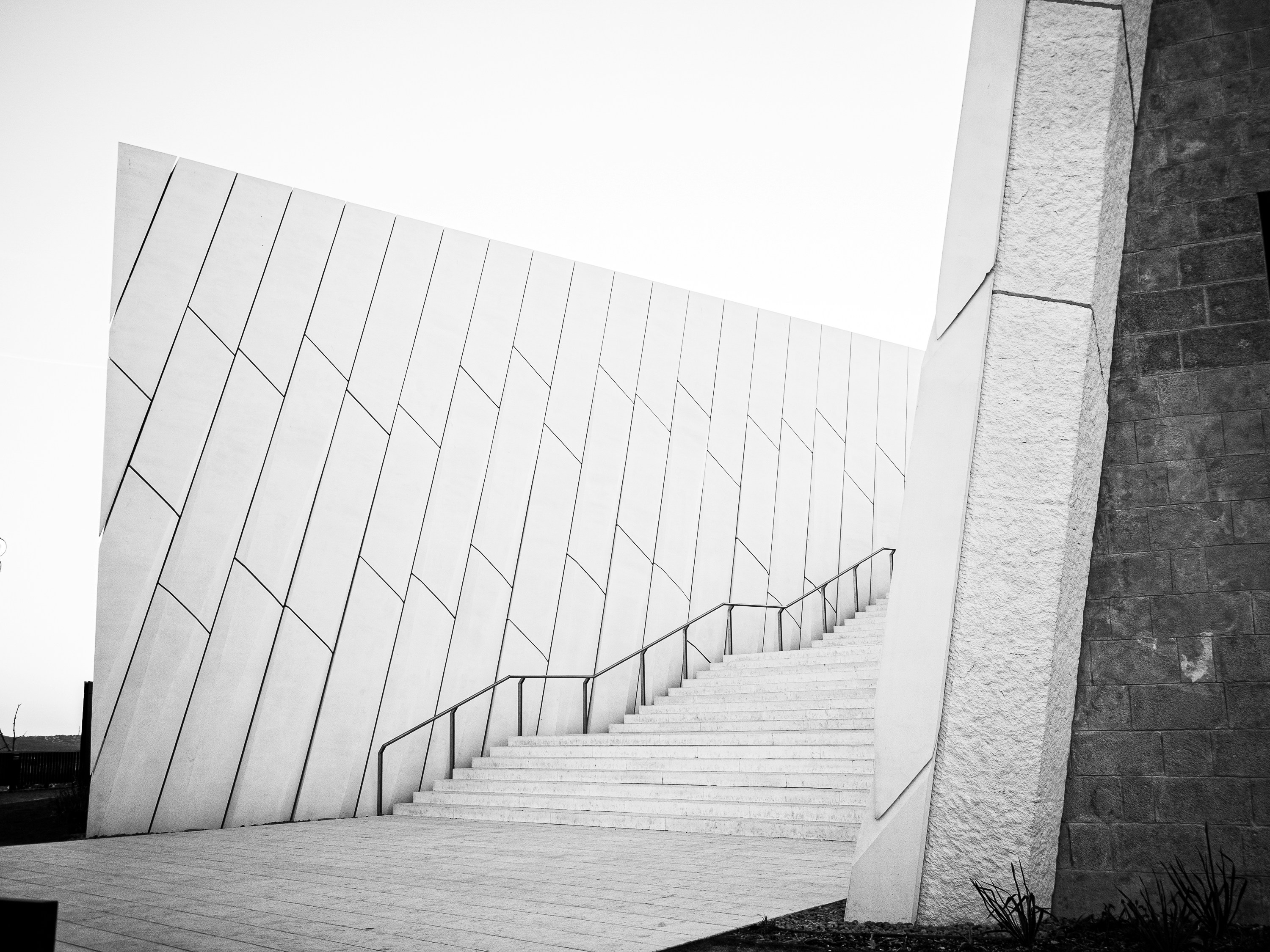 Concrete Ascent: A Monochrome Staircase Between Angular Facades