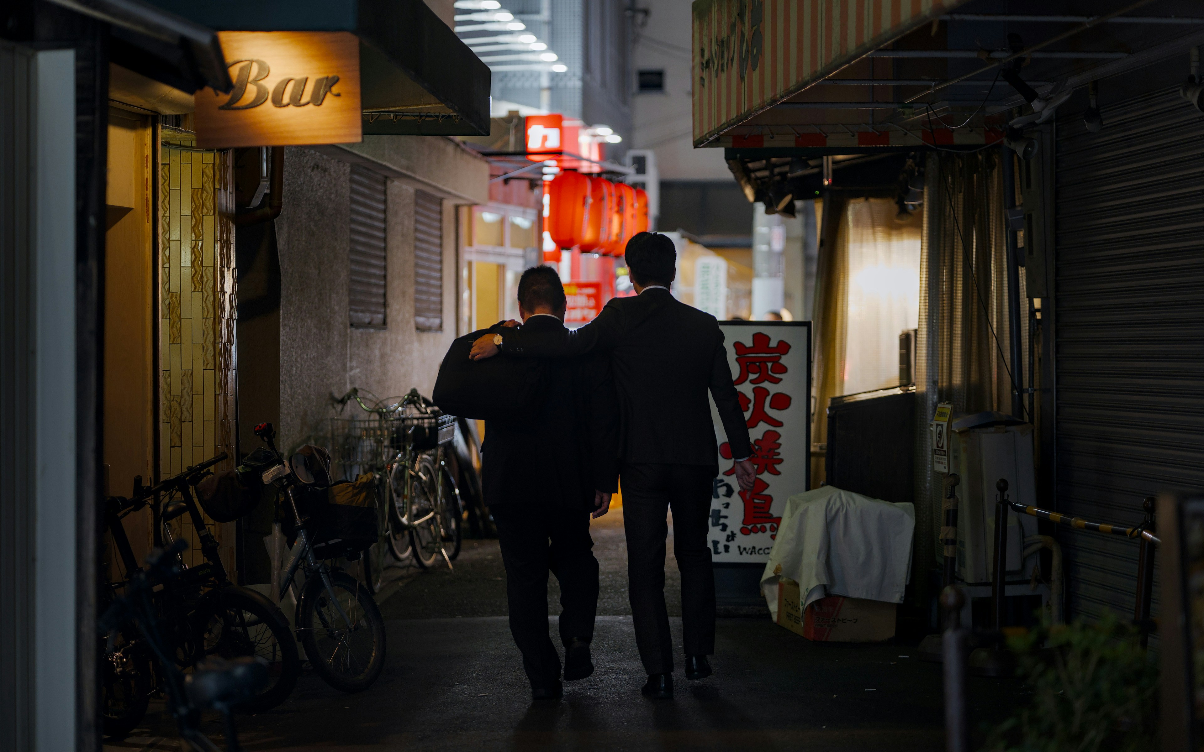 Two silhouettes in a neon-lit alleyway share a quiet moment