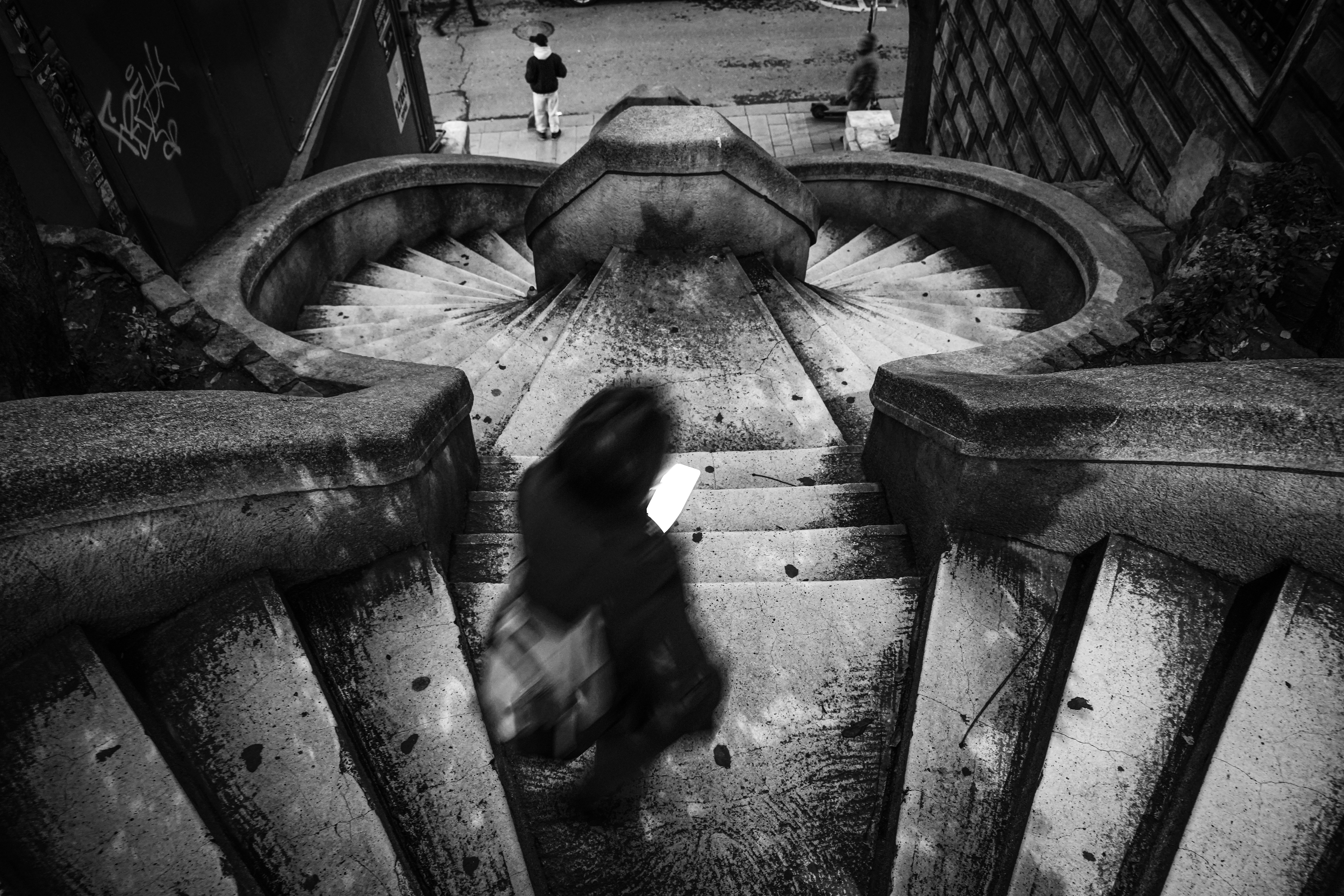 A Silent Stairway: Traveler Descends an Echoing Urban Spiral