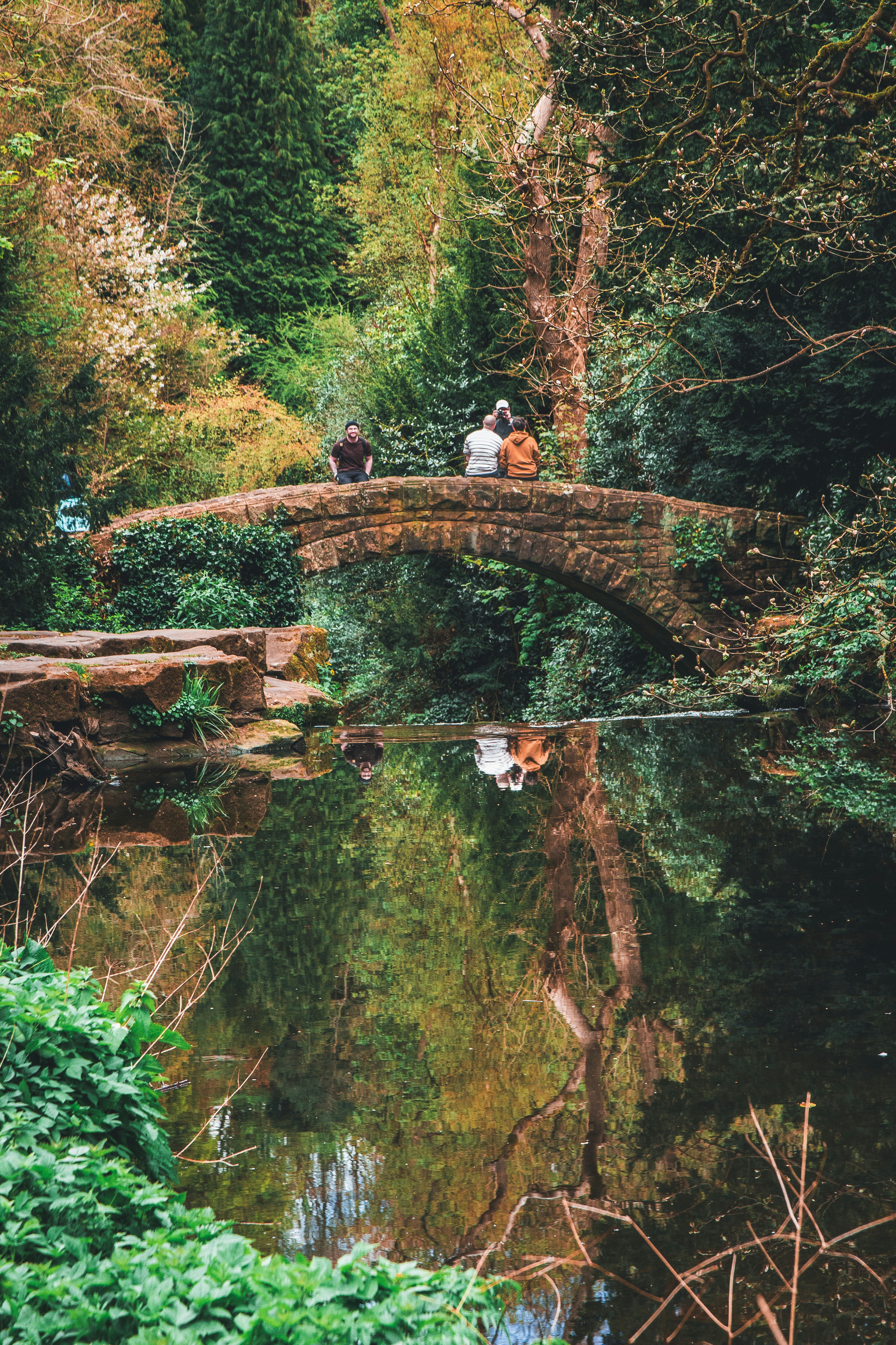 Autumn Bridge Reflections: People at the Stone Arc
