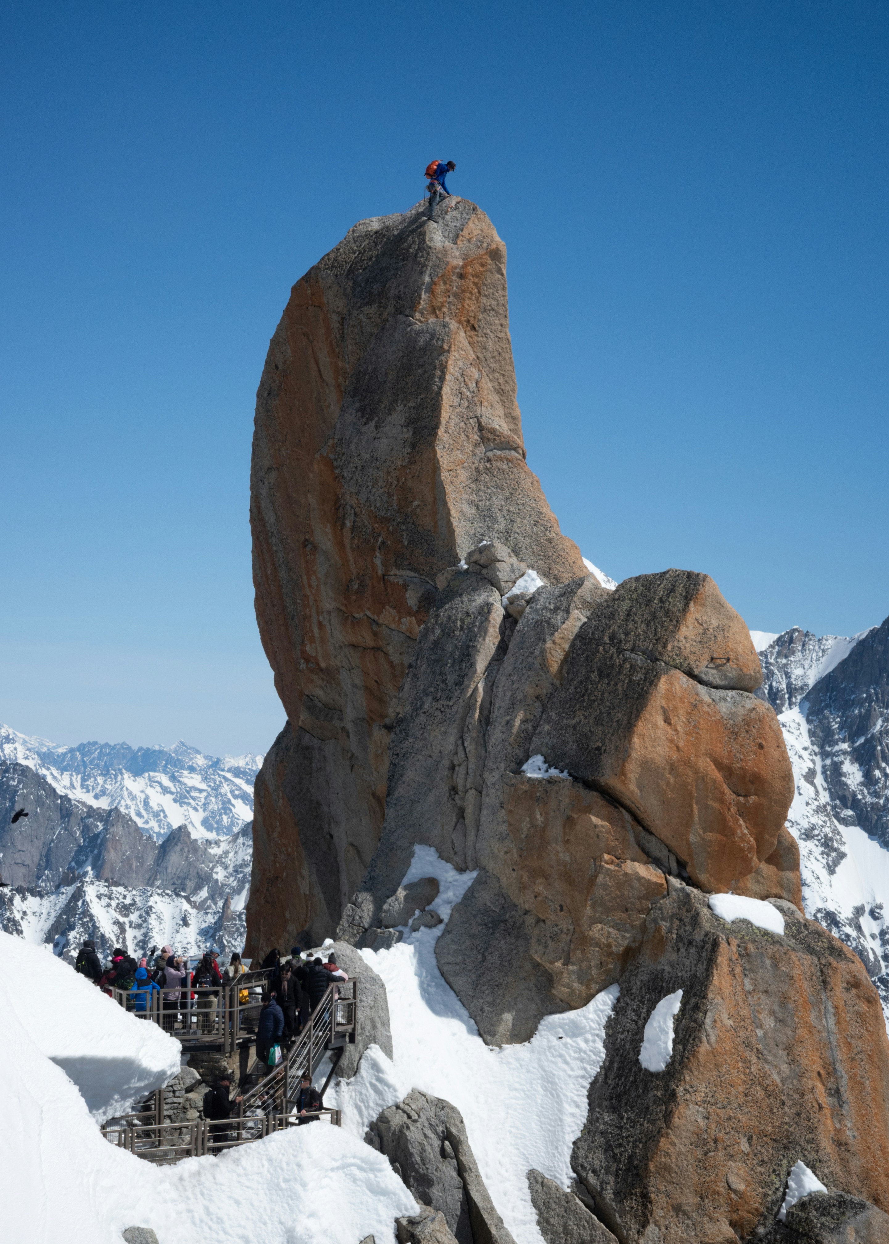 A Climber Reaches the Summit of a Serpentine Rock Peak
