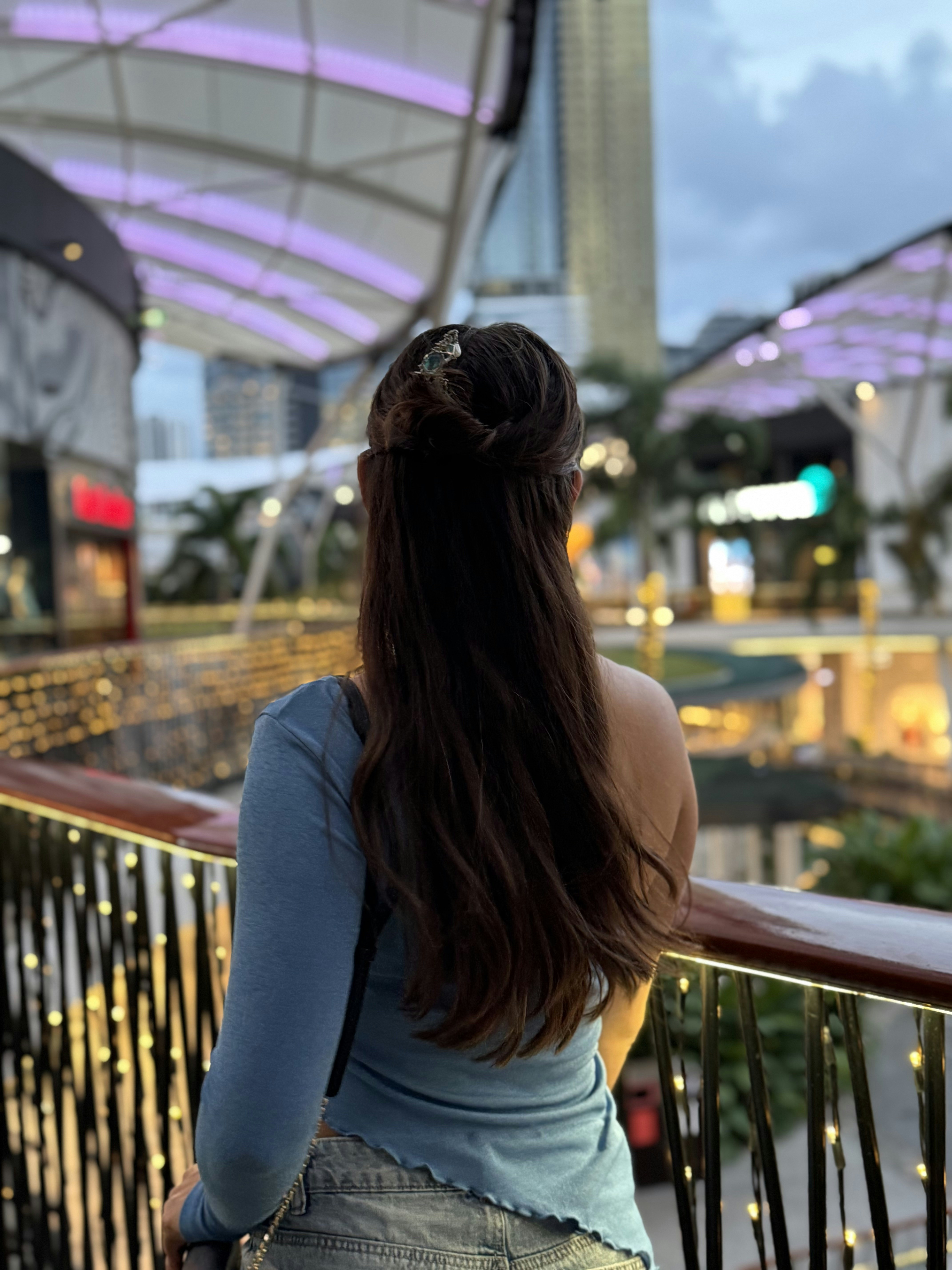 A Corridor of Neon Nights: Woman in Blue on the Balcony