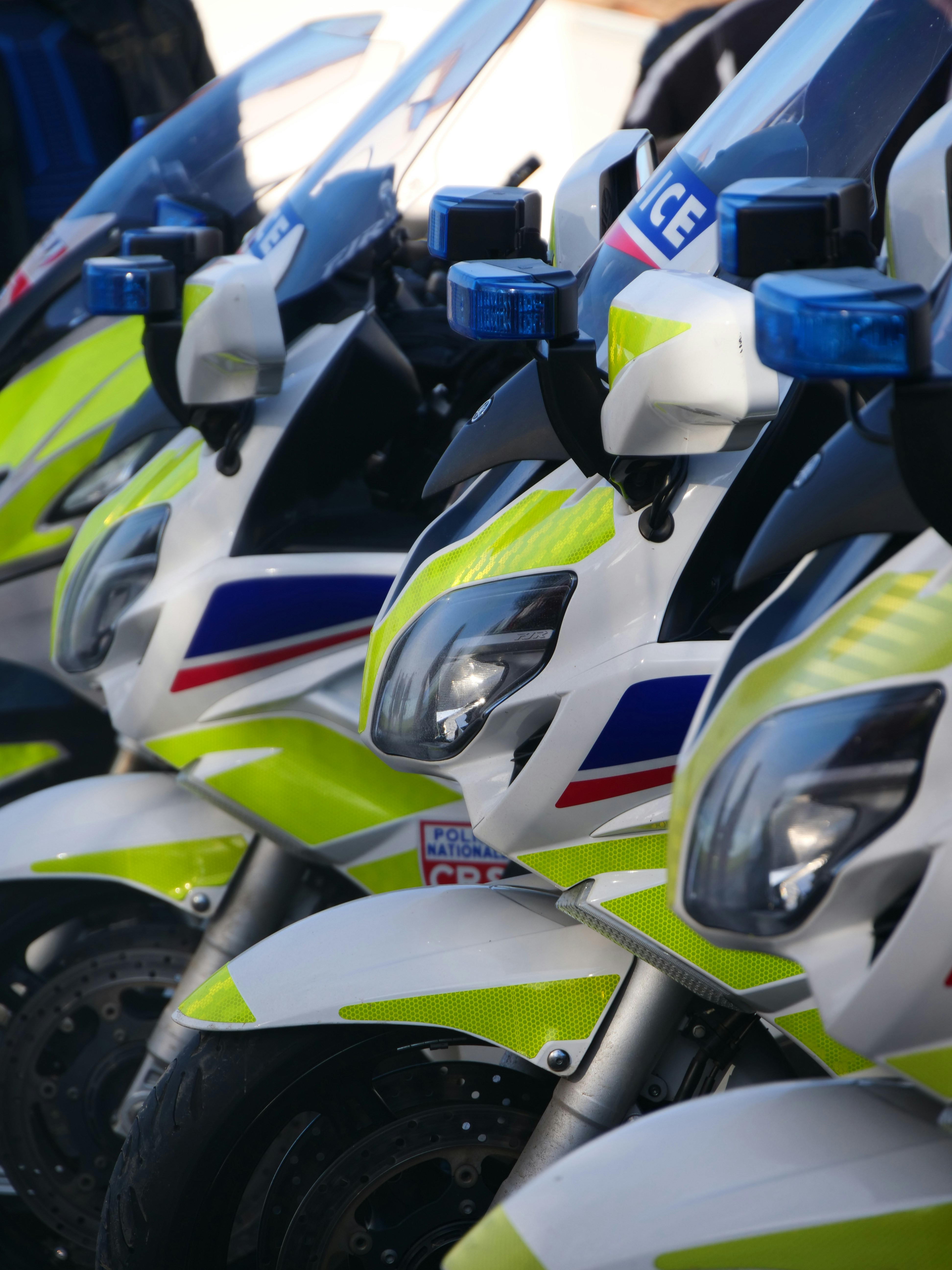 Line of Polished Police Motorcycles: Reflective Yellow Stripes and Blue Lights in Profile