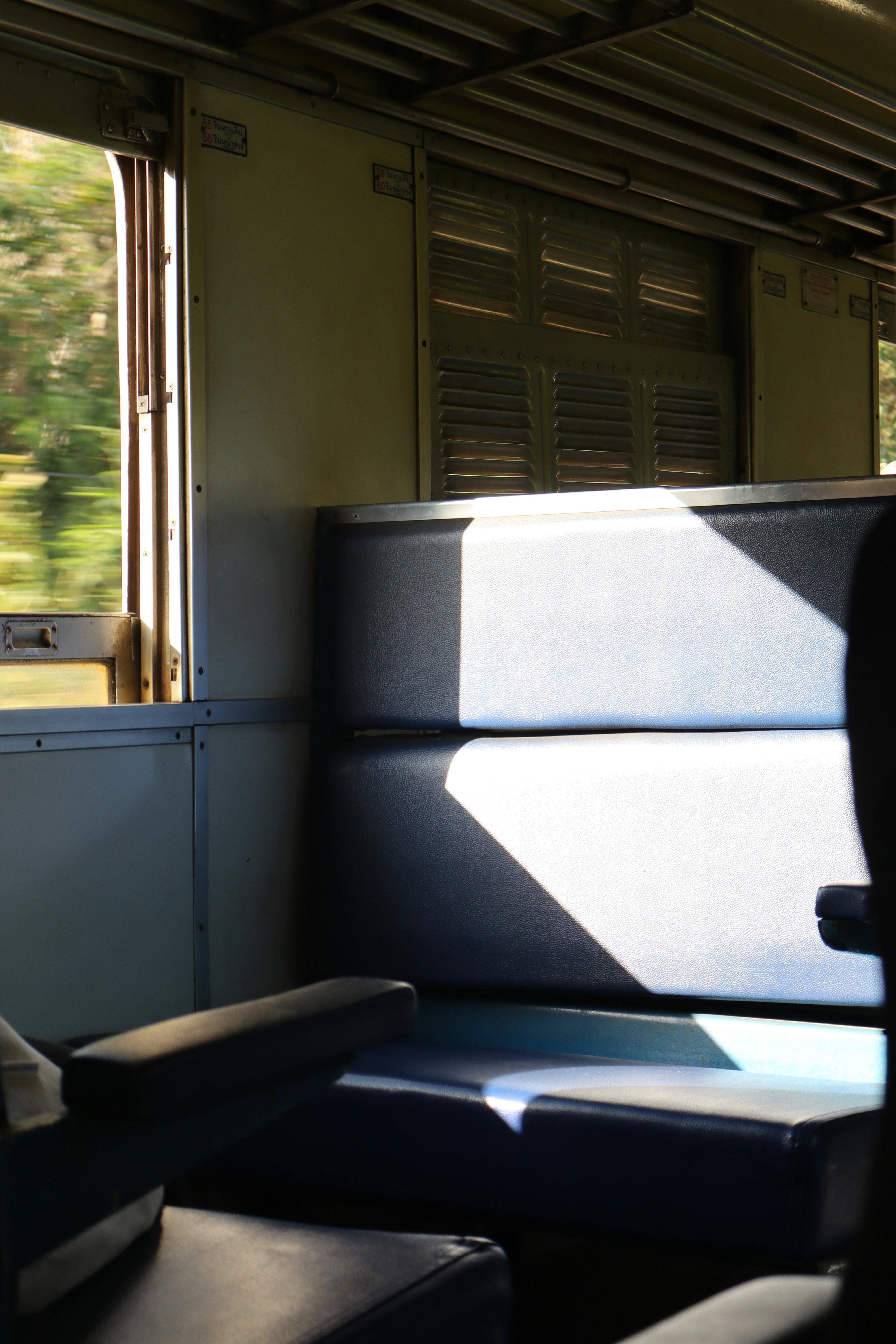 Sunlit Bench Within a Quiet Train Car