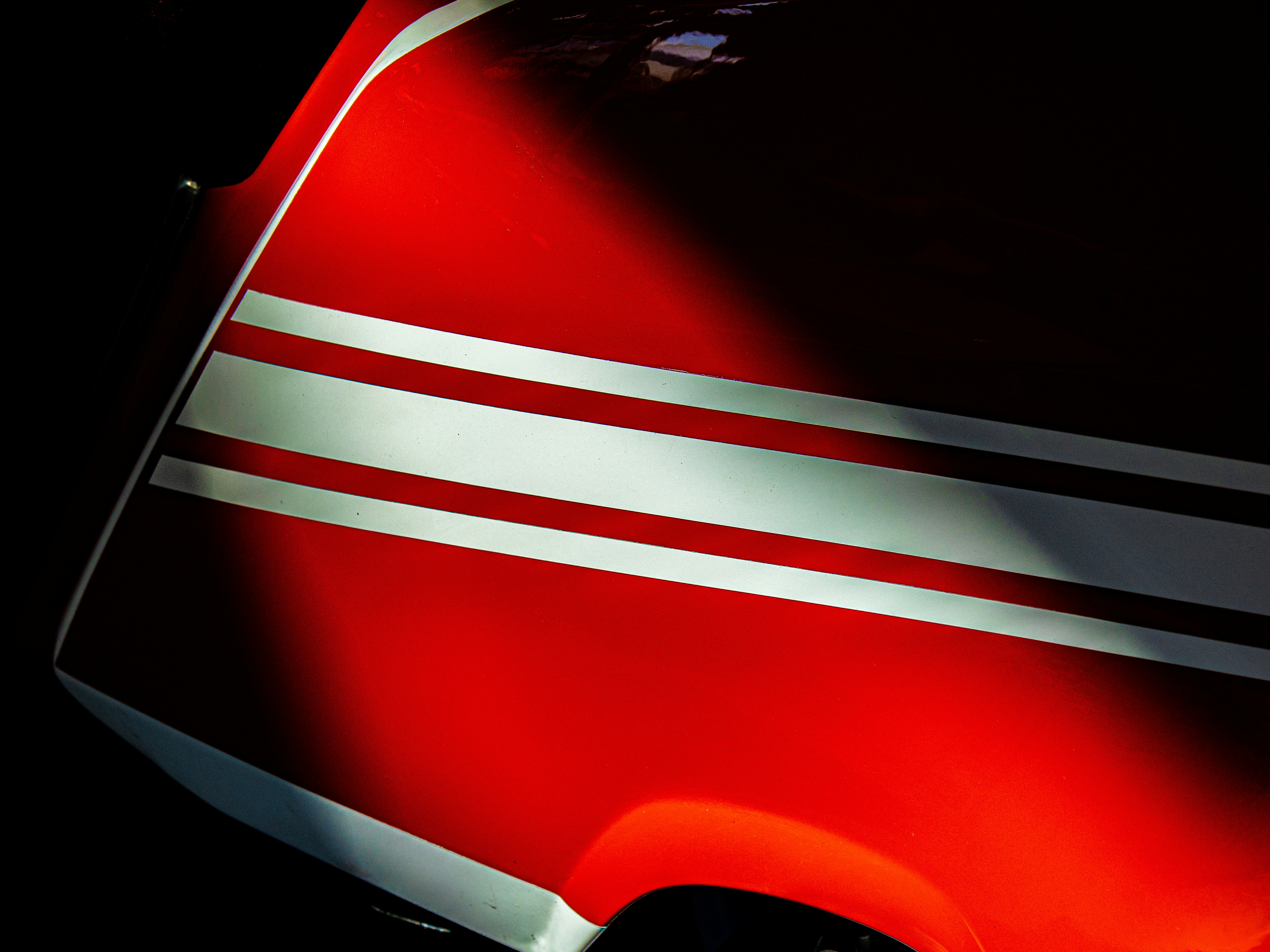 Red Stripes on a Shaded Hood: A Car’s Quiet Edge