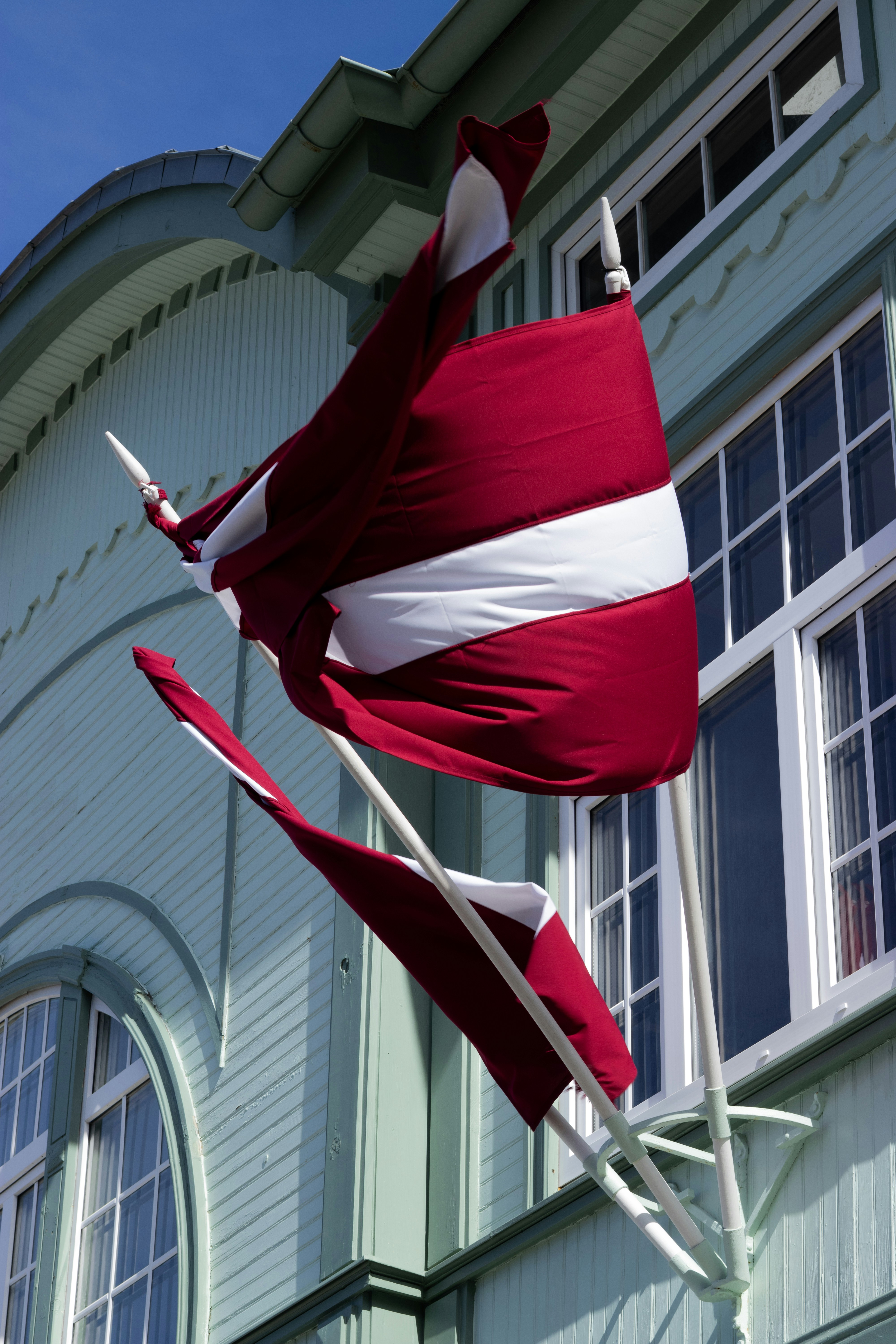 Red‑and‑white banners flare against a mint green façade