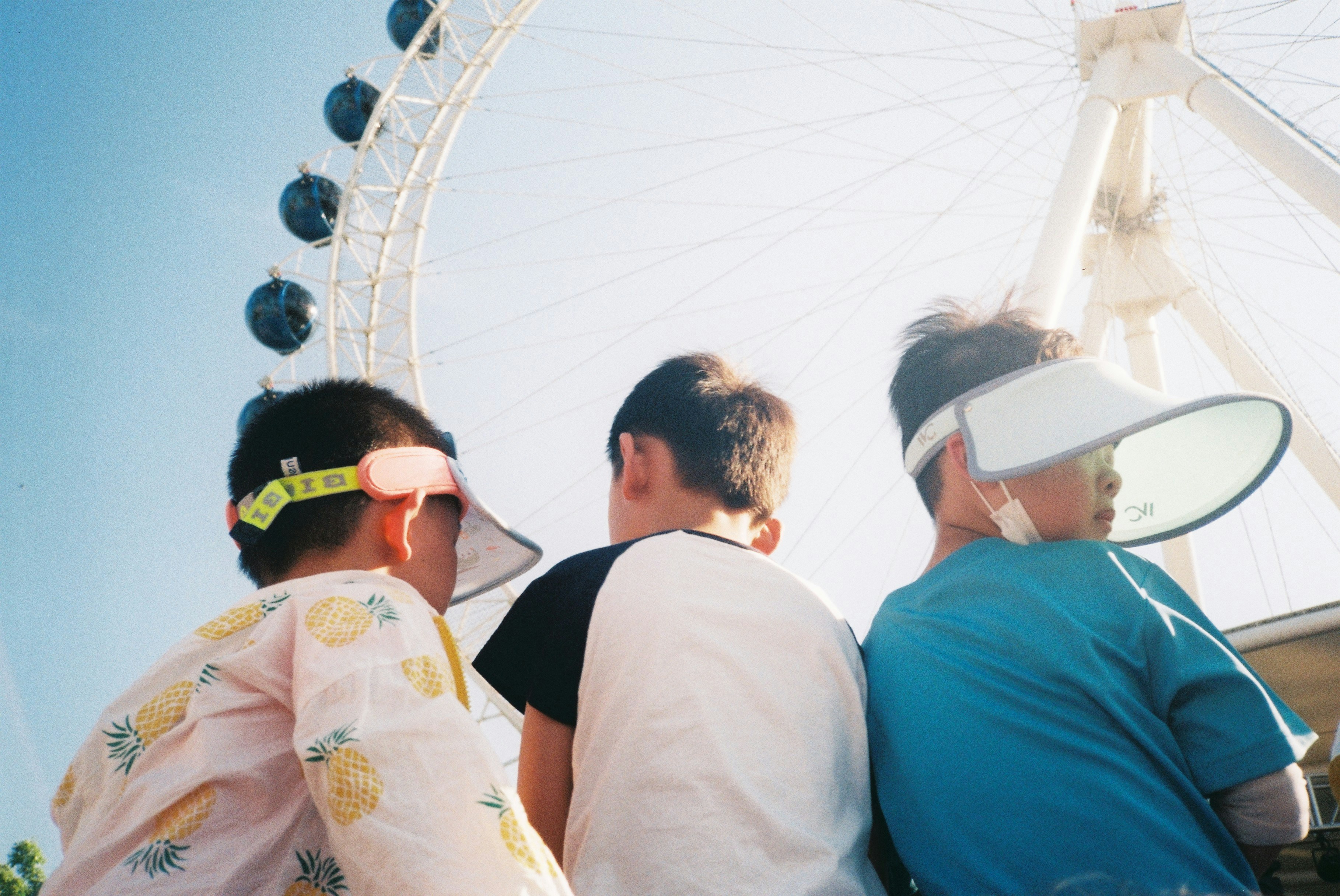 Ferris Wheel Gaze: Children in Summer Shade