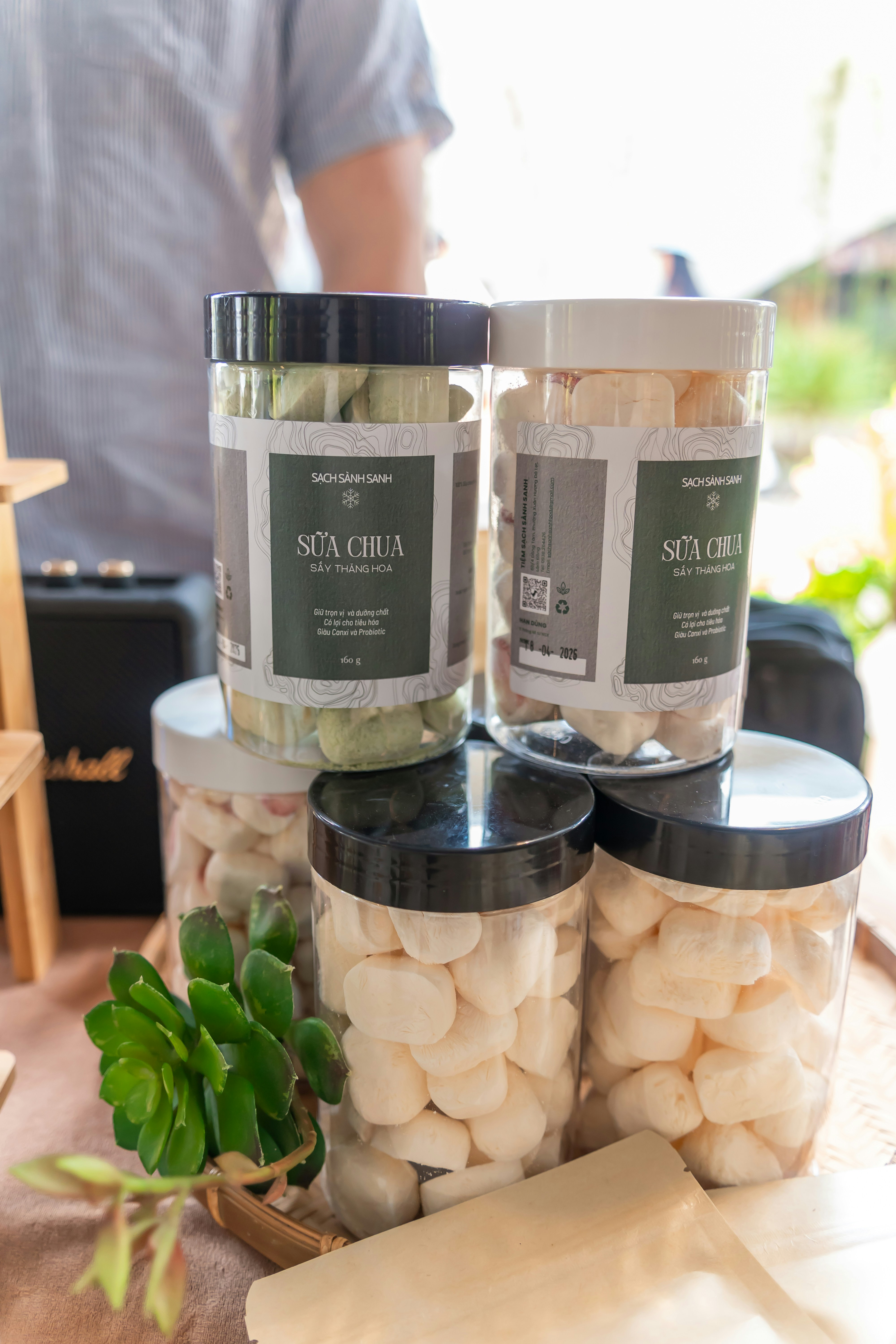 Stacked jars of snacks: a sunlit still-life with a hint of greenery