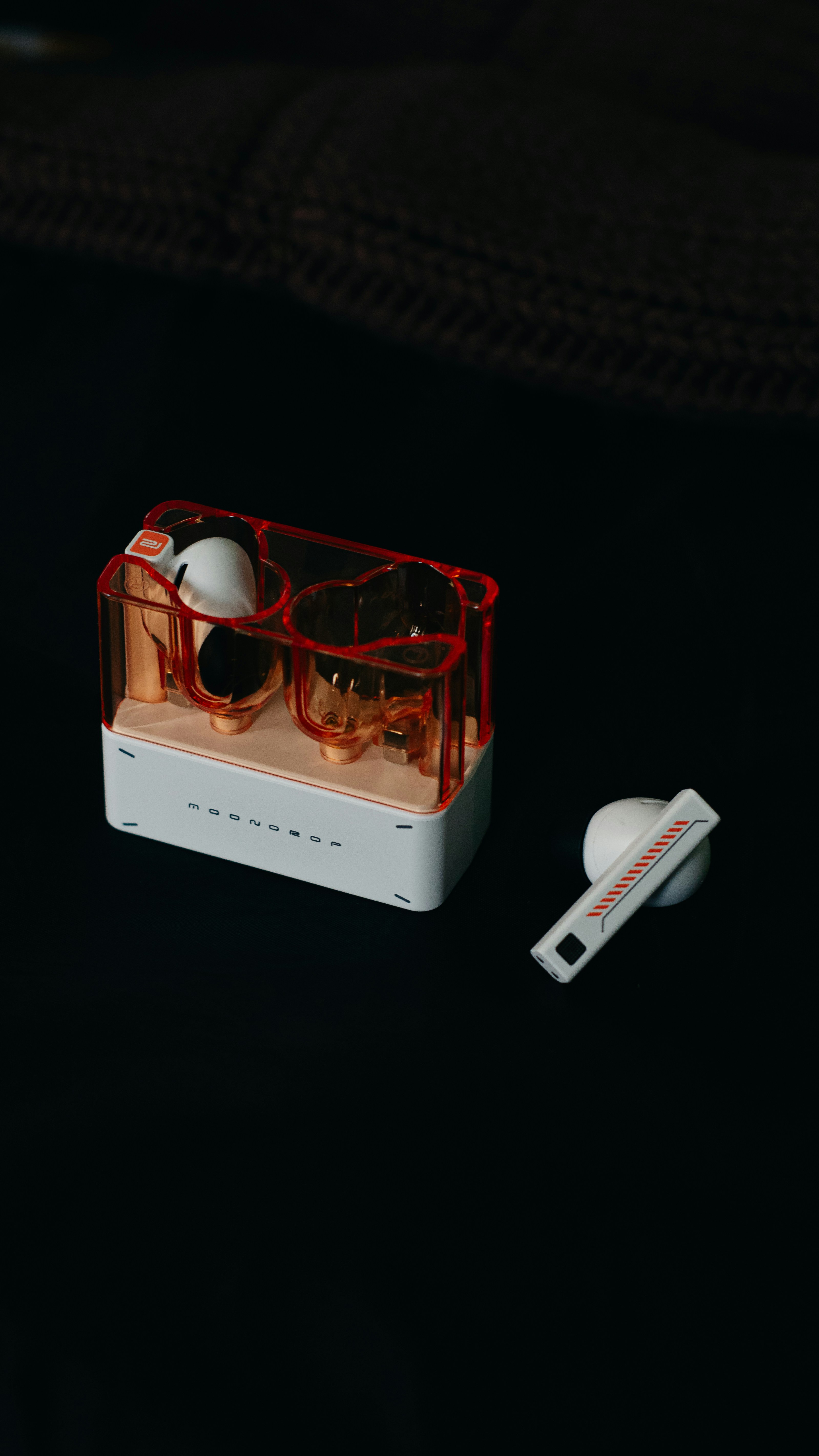 Red-Trimmed Earbuds: A Minimal Still Life of Tech on Velvet Night