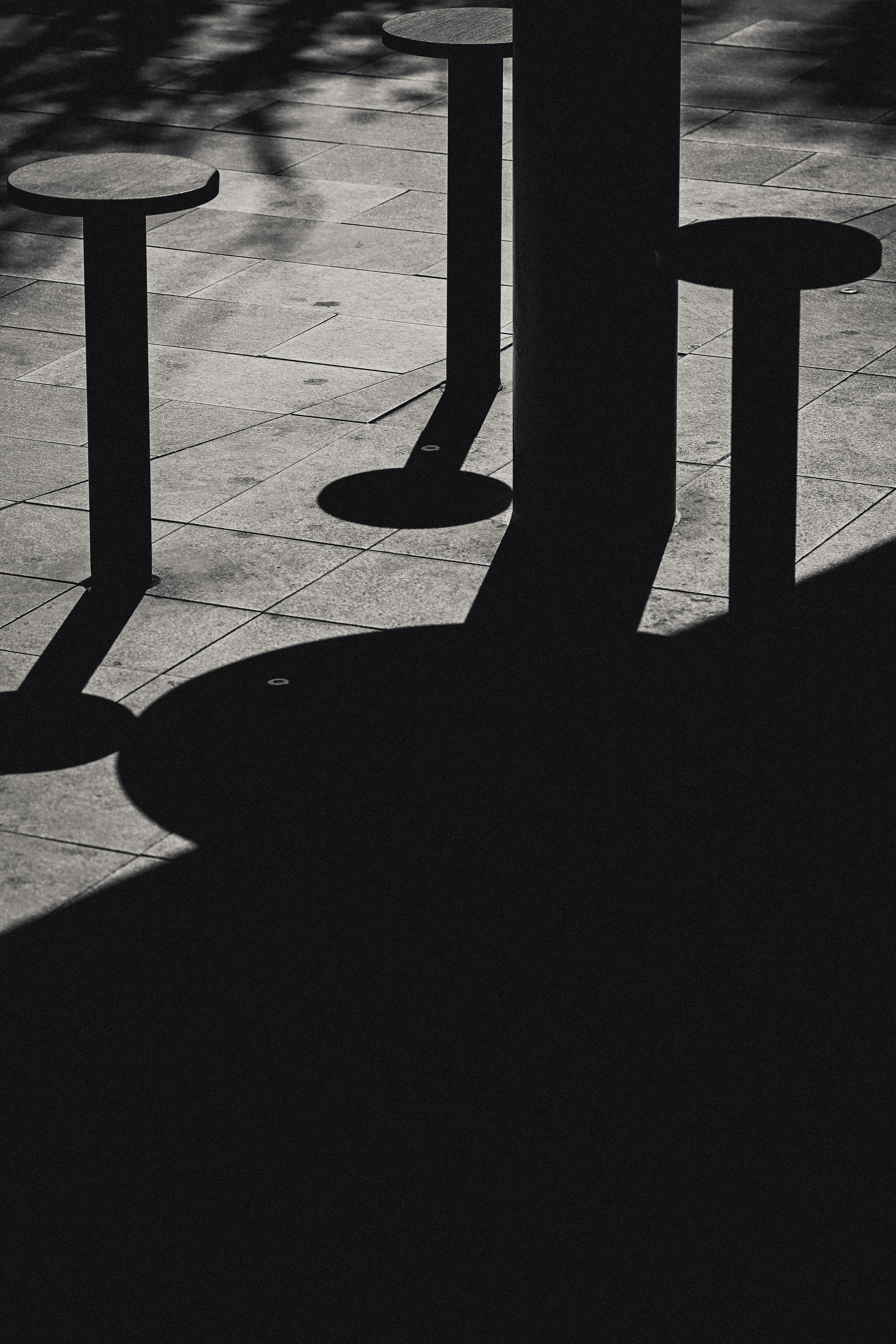 Shadowed Stands: Minimalist Street Sculptures in Light and Shade