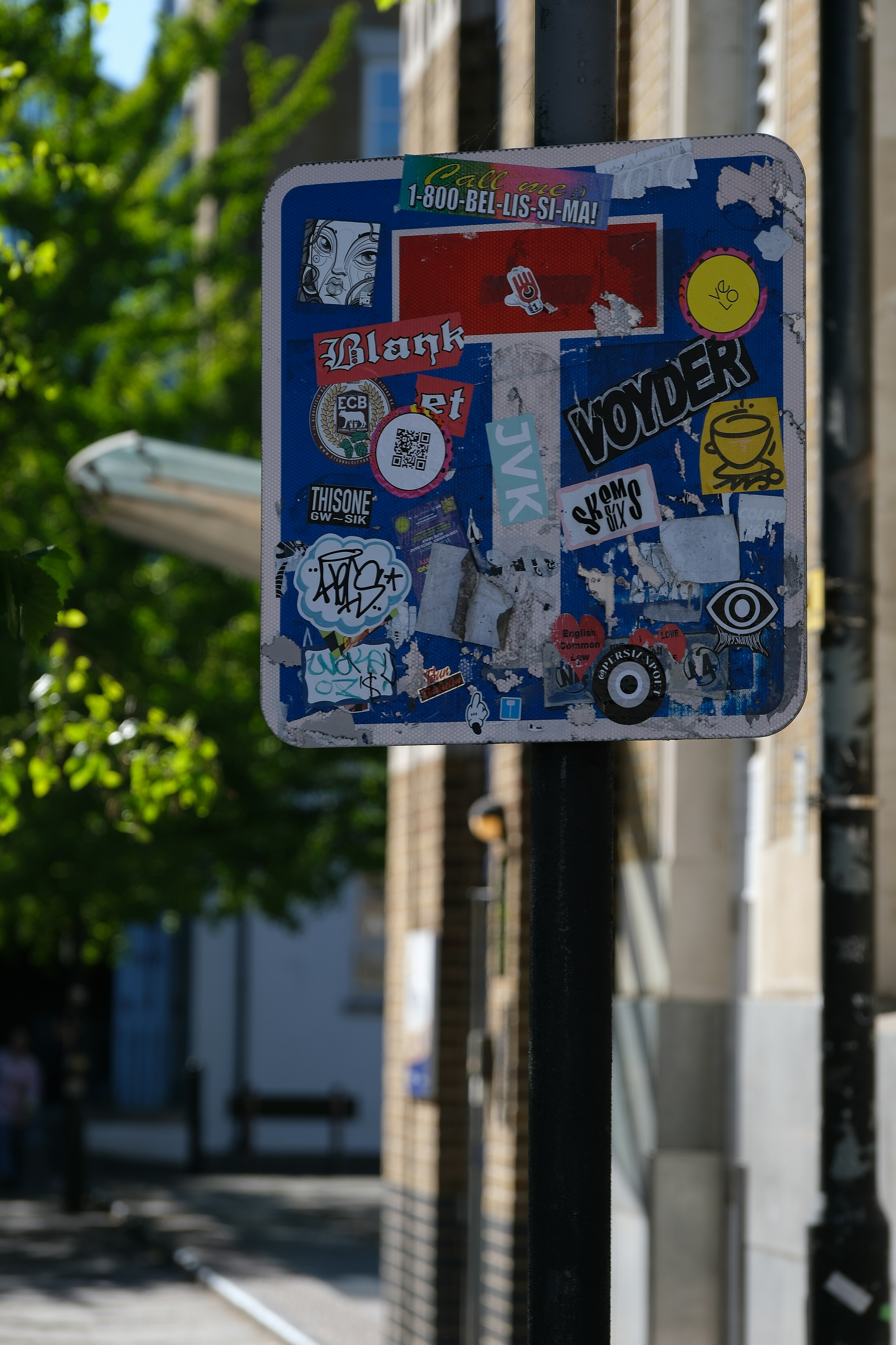 Stickered Signpost: Colorful Urban Patchwork on a Street Entrance