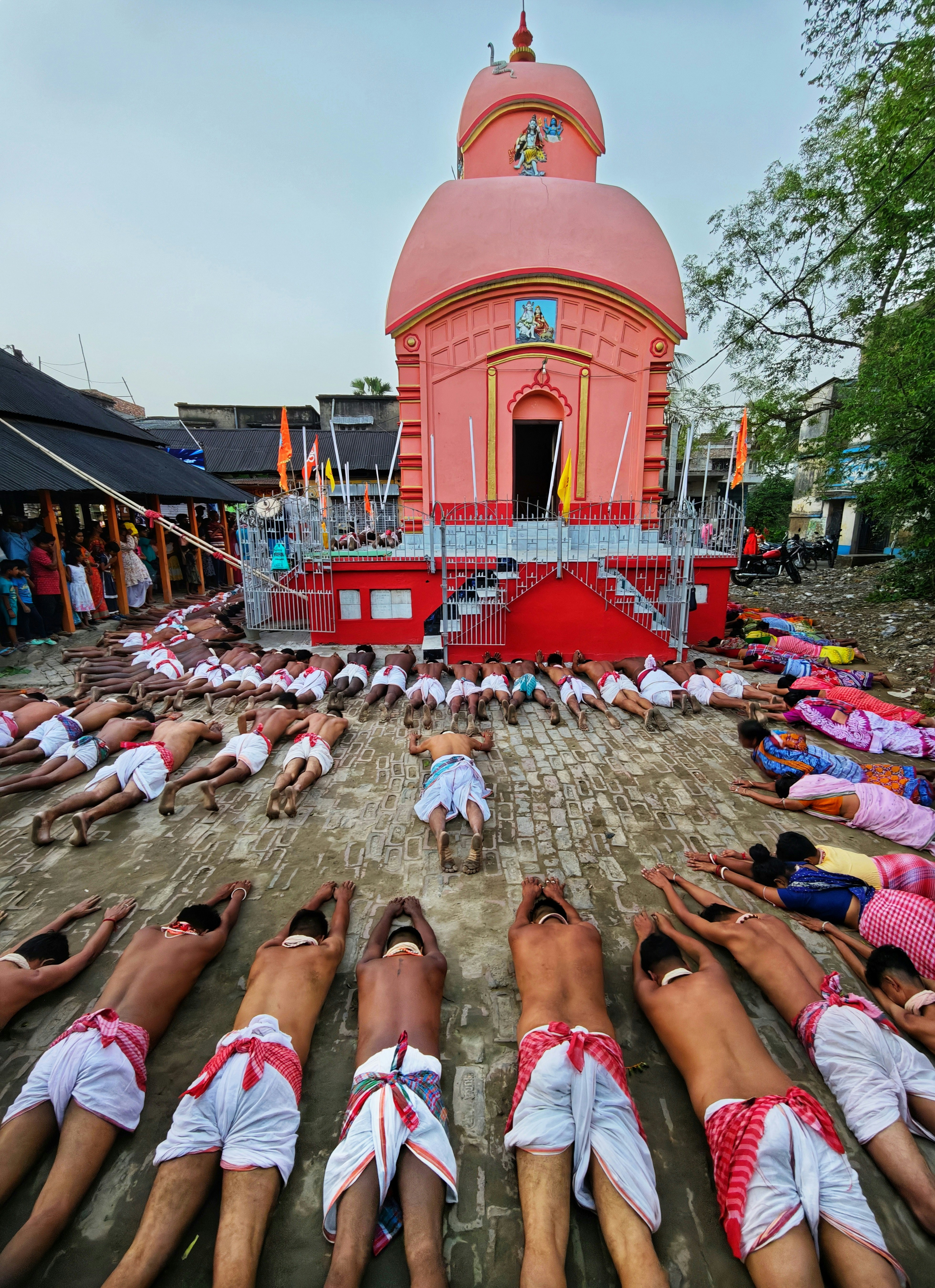 Massed Devotional Posture Before a Pink Shrine