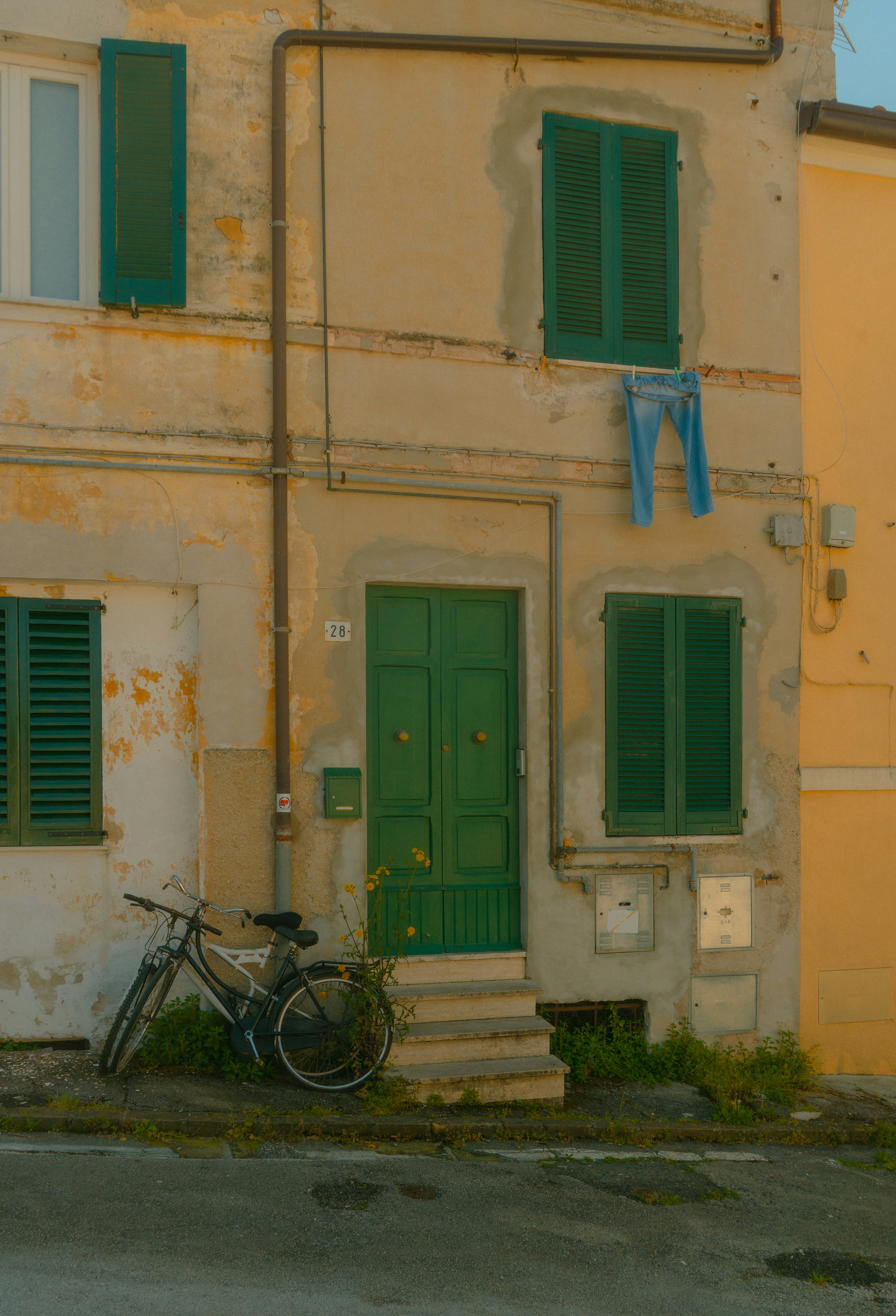 Green Doorway and Quiet Street in Warm Italian Facade