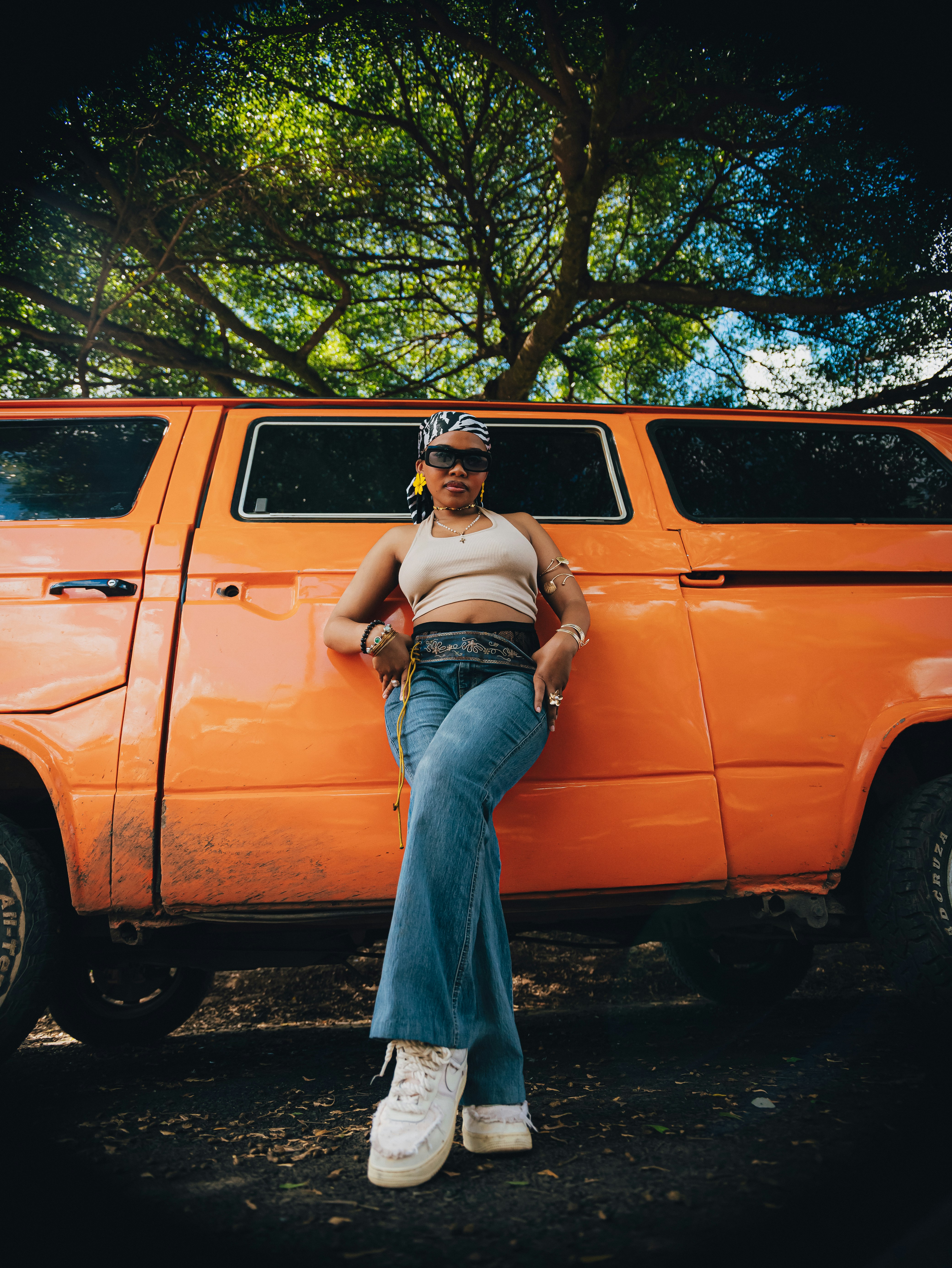 Orange Truck, Cool Confidence: Portrait of a Woman Leaning on a Vintage Ride