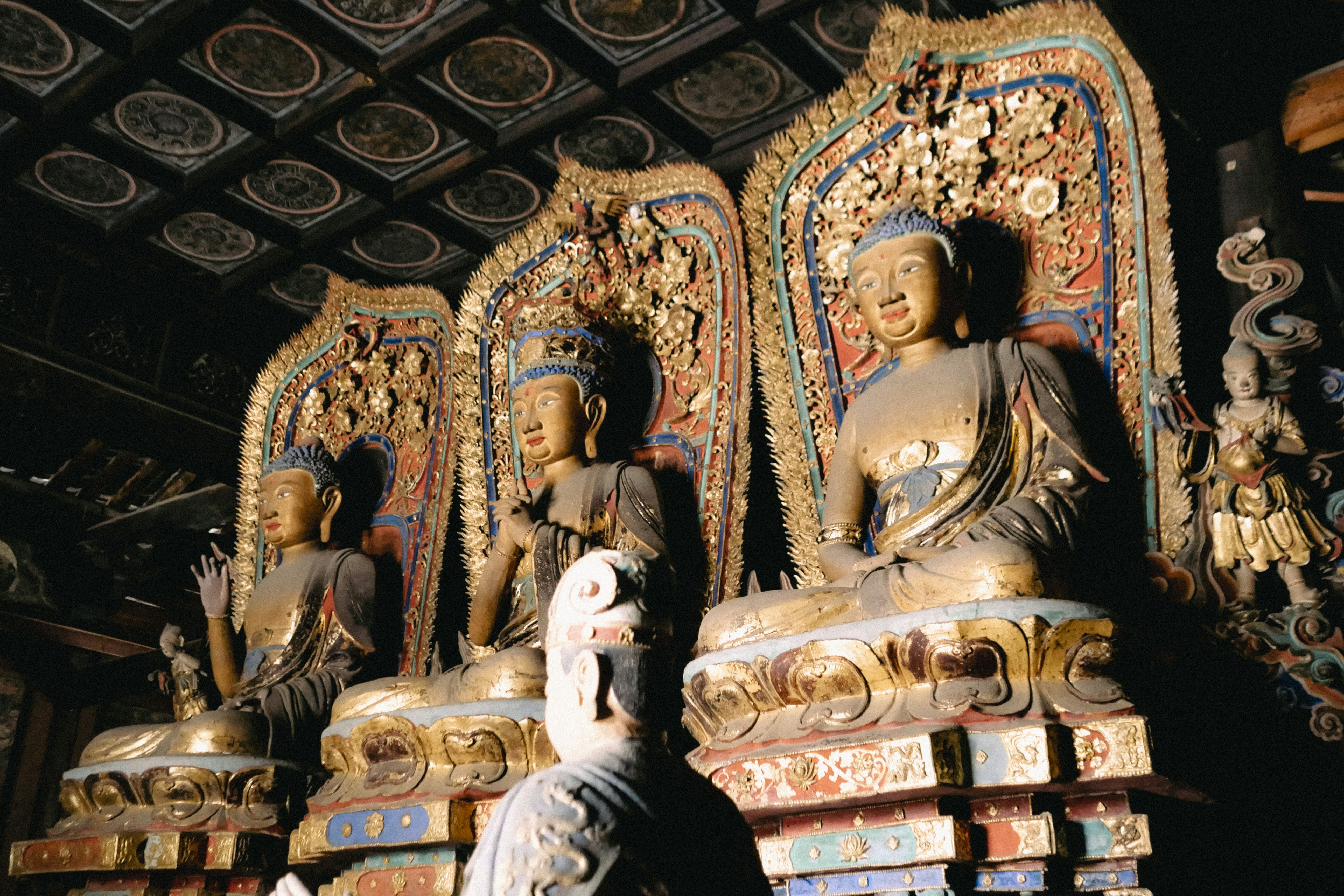 Muted Reverence: Three Buddhas in a Dim Sanctuary