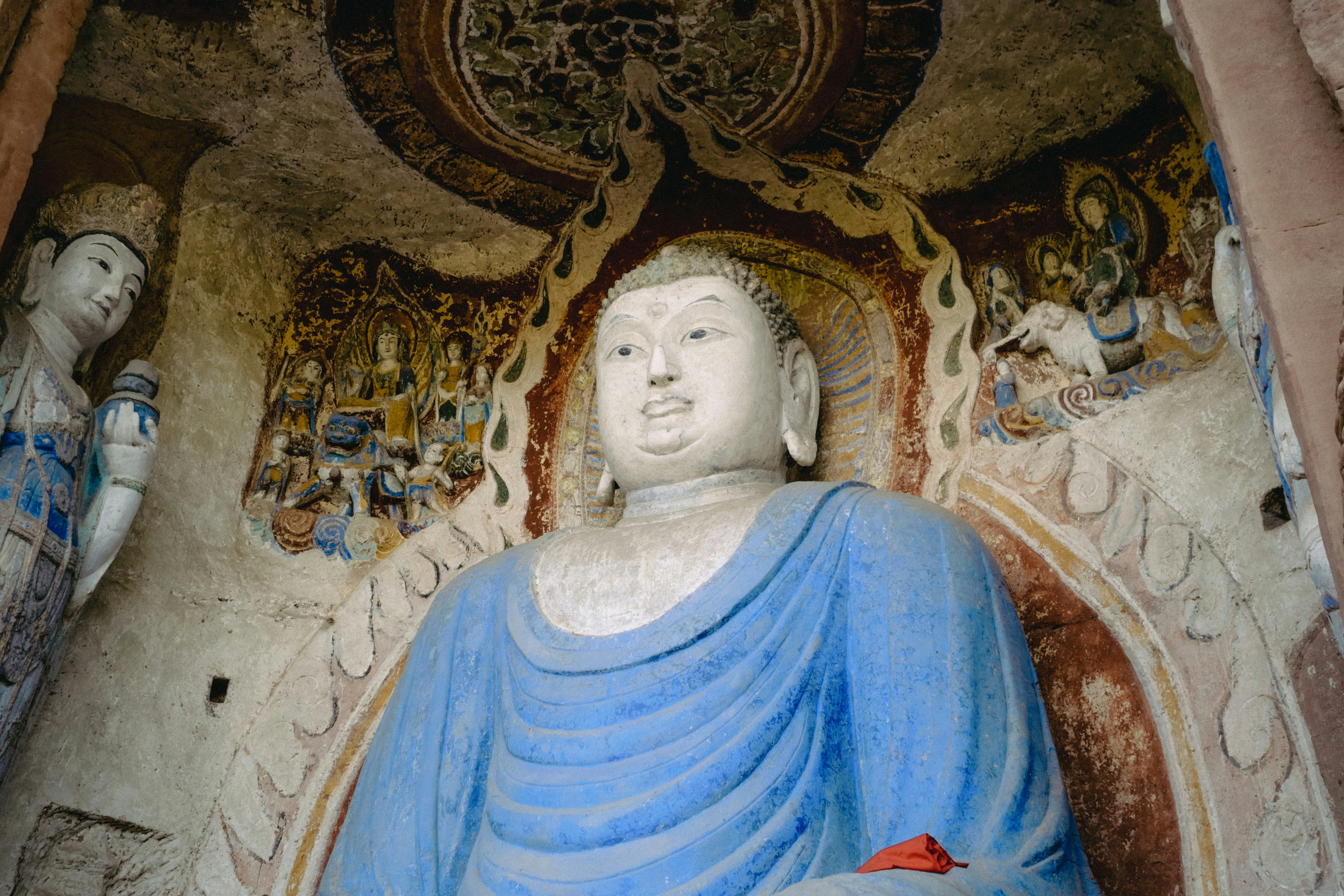 Blue-robed Buddha Statuary Surrounded by Shrine Frescoes