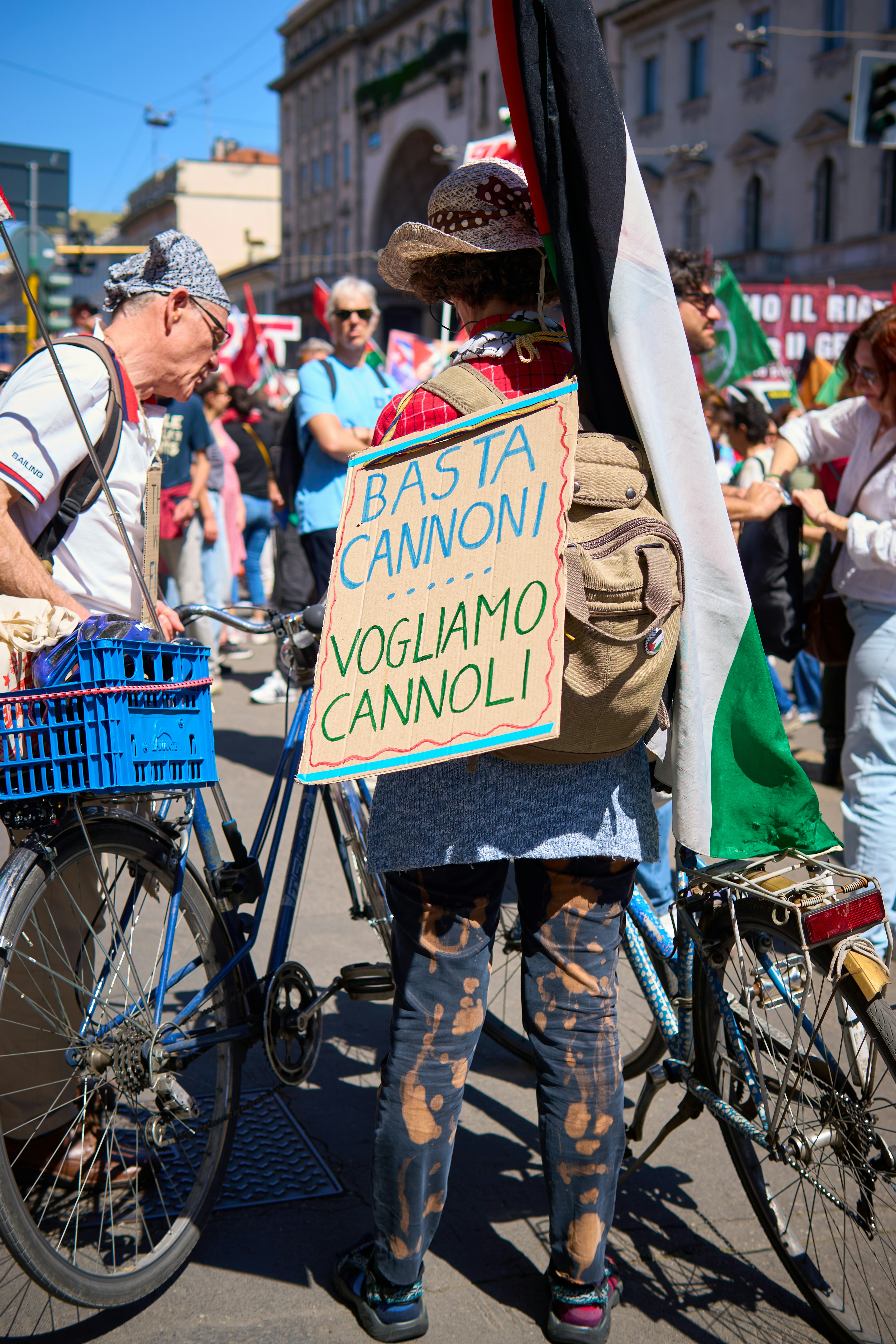 Sign-Bearing Protester Between Bicycles in a Sunlit Street