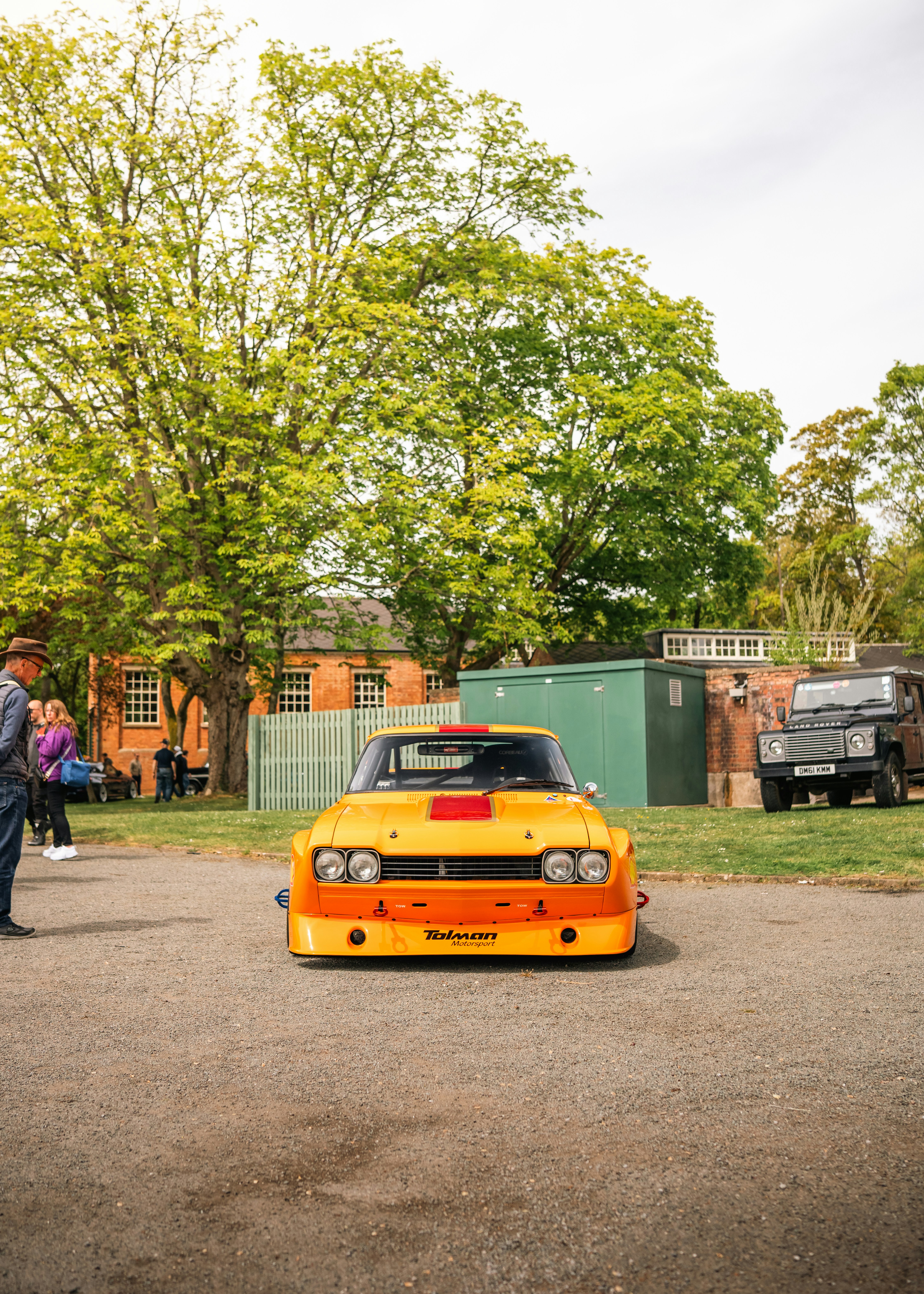 Orange Triumph: A Classic Race Car Reposes in a Sunlit Courtyard