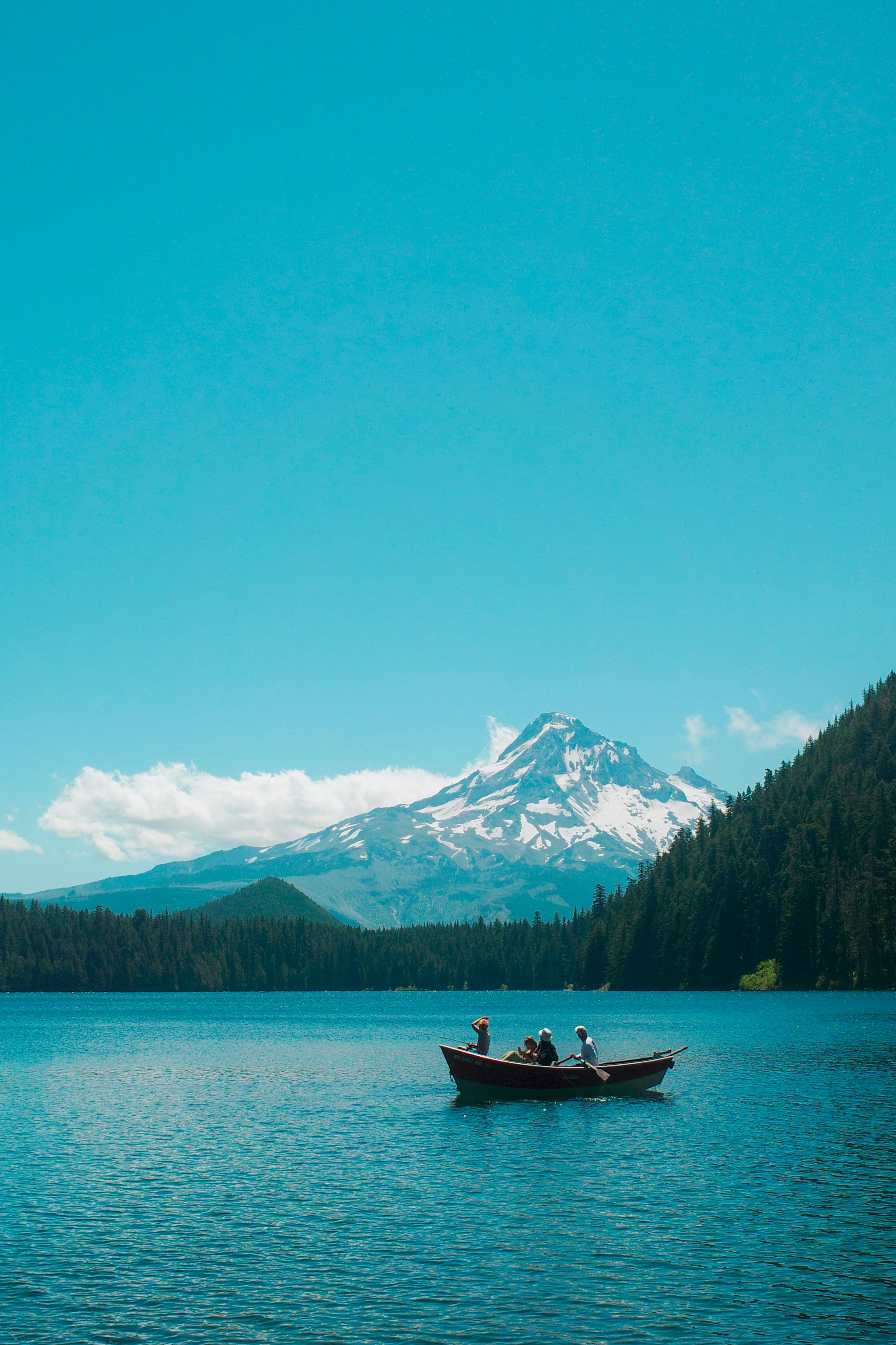 Boat on a Serene Alpine Lake Under a Clear Blue Sky