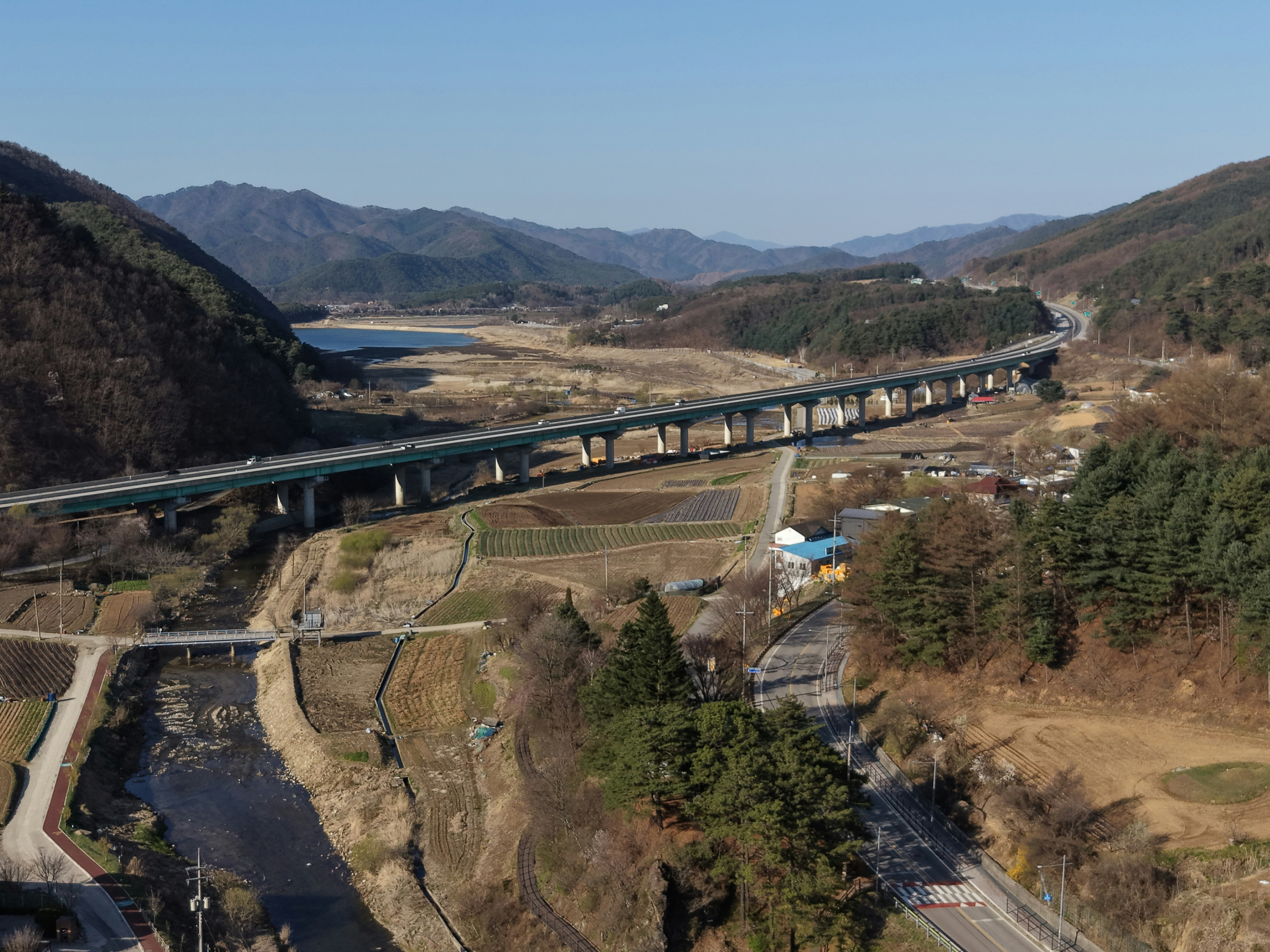 Coastal valley highway arcs through sunlit hills
