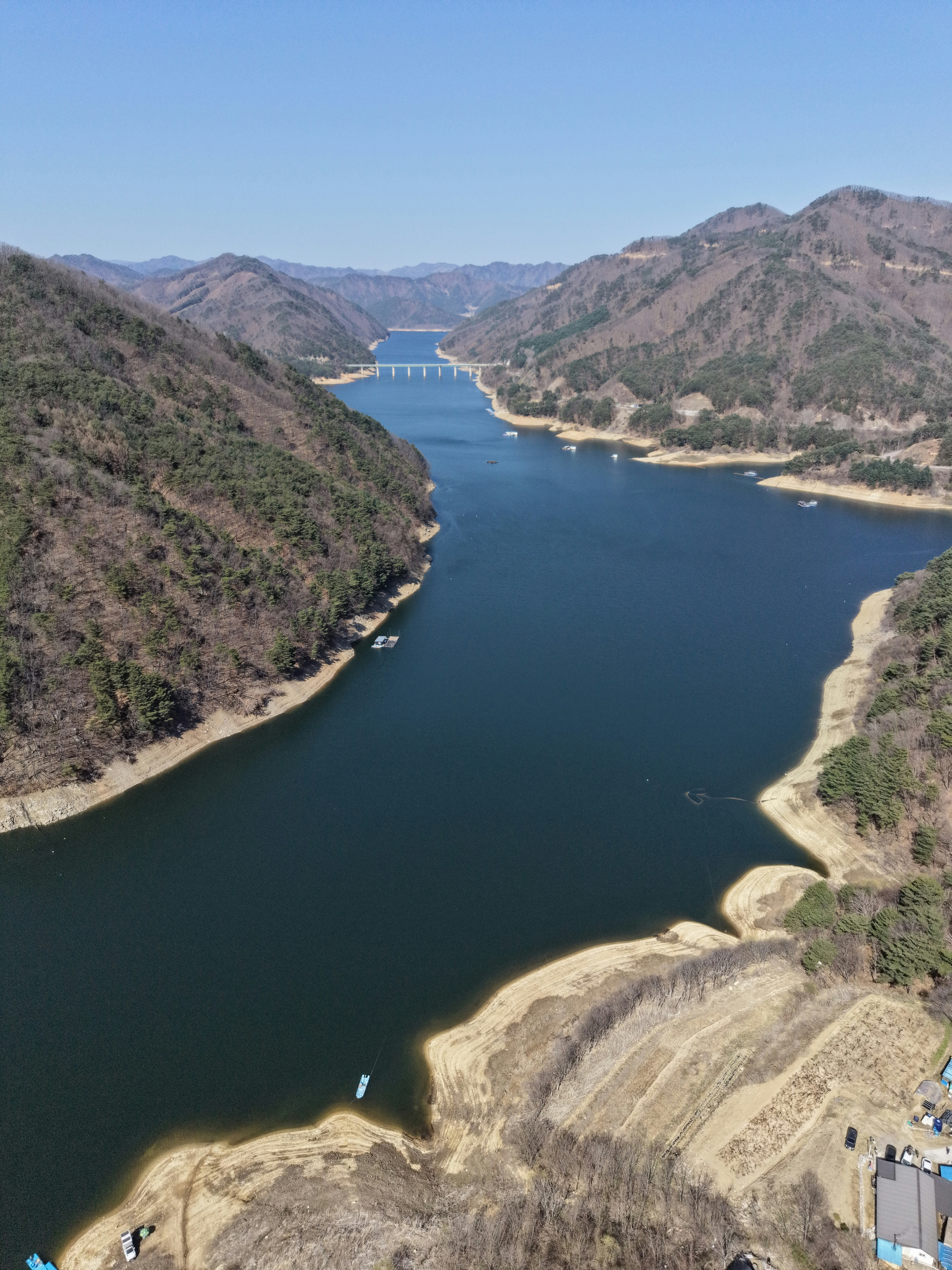 River Between Silent Peaks: Aerial Where the Water Snakes Through Gorge