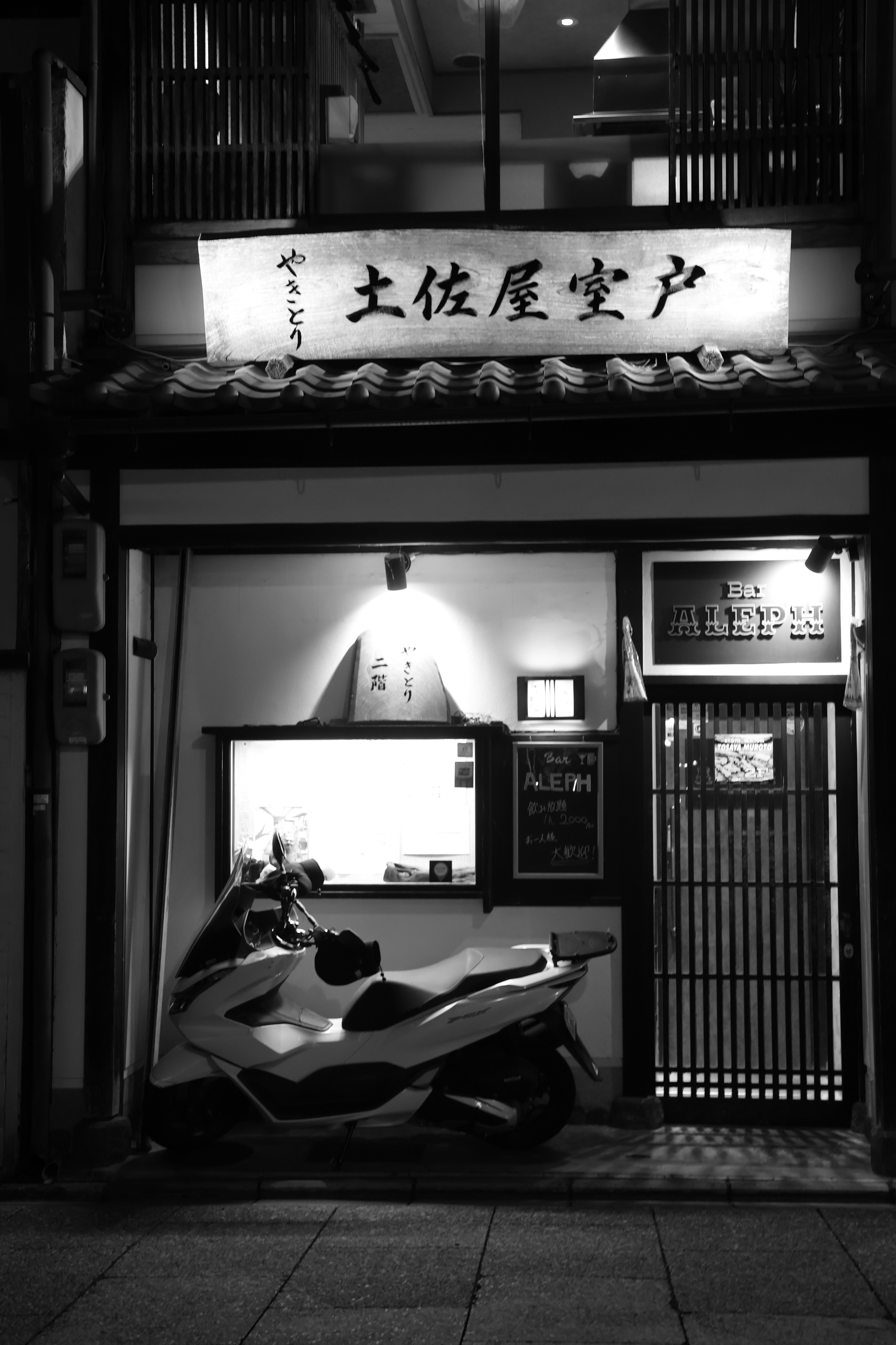 Nightlife Aglow: Neon Sign, Scooter, and Japanese Facade