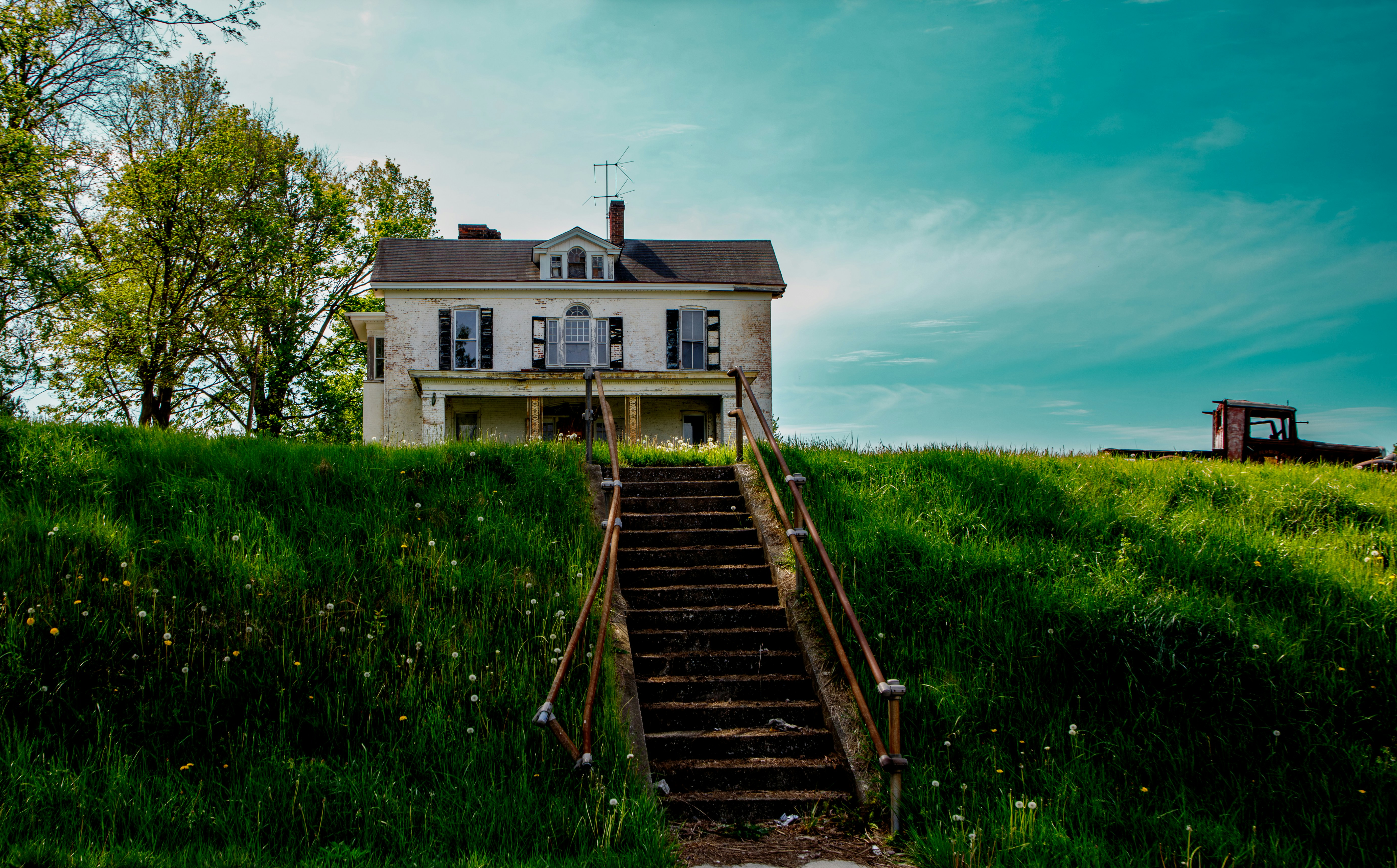 A Quiet Hallway Stairway to a Cottage–Like House in a Green Field