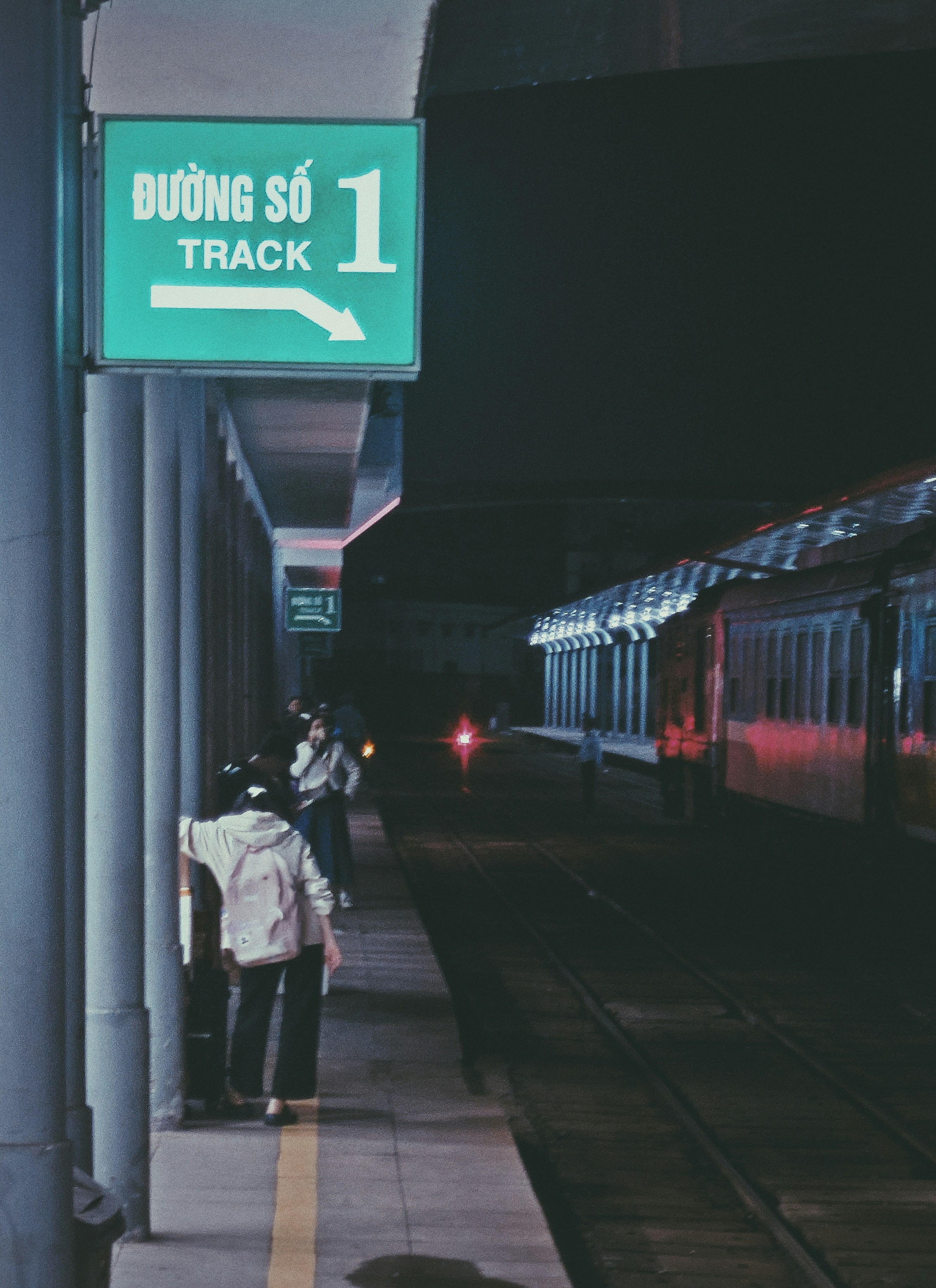 Night Platform Signage and Silhouettes: Studio-green Sign at Track 1