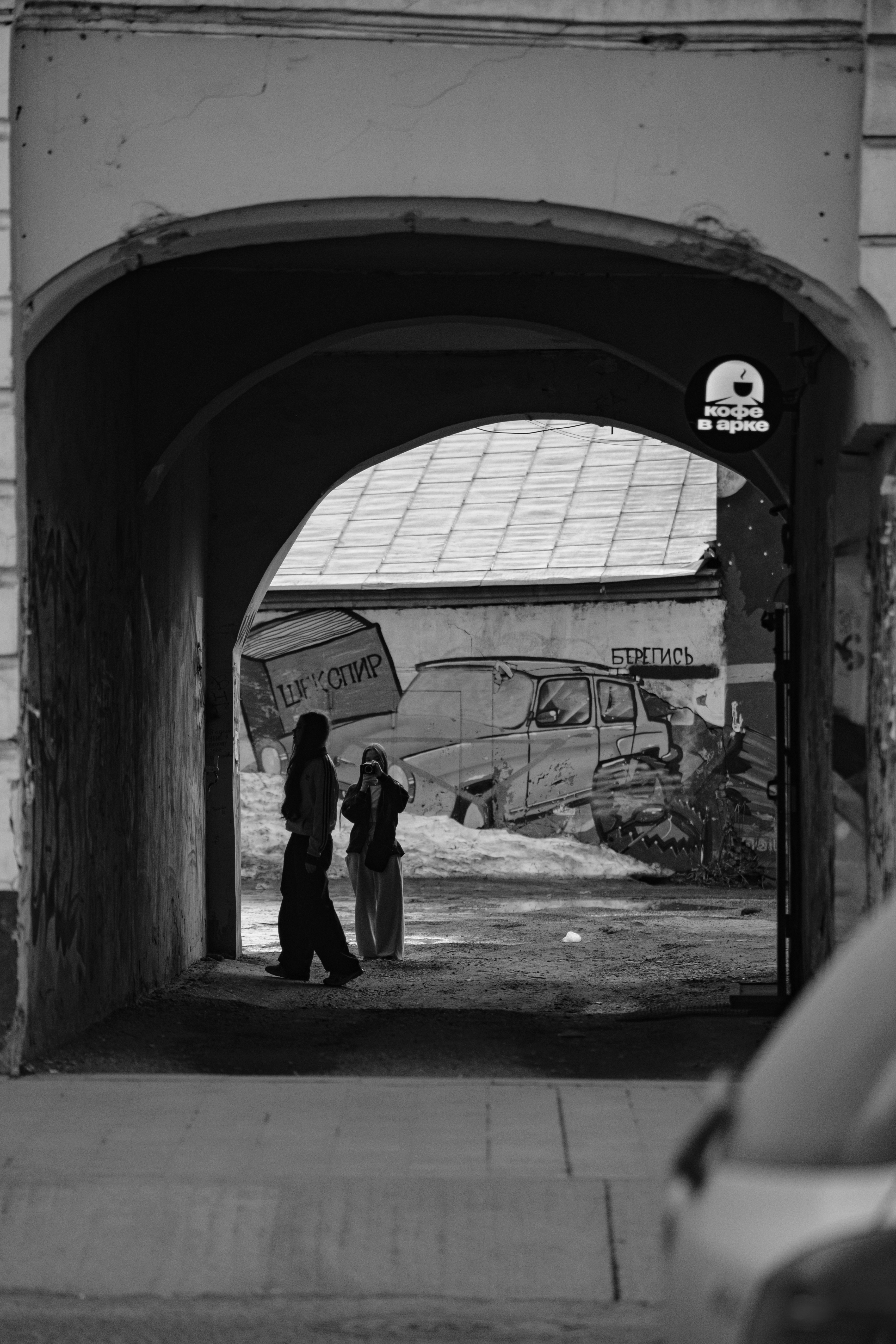 Under the Archway: Two Figures in a Graffitied Tunnel