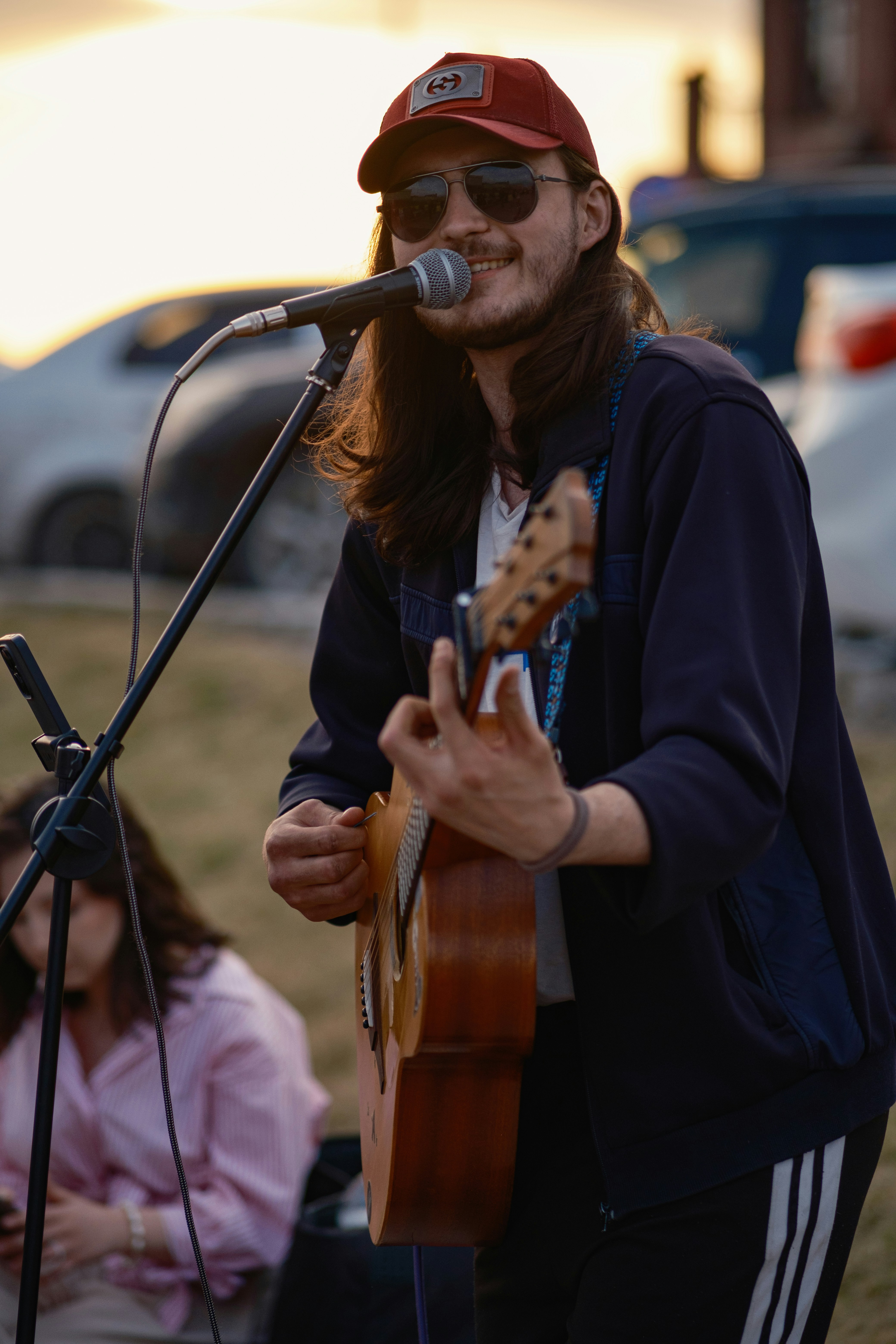 Sunlit Strings: Performer with Guitar under Sunset Glow