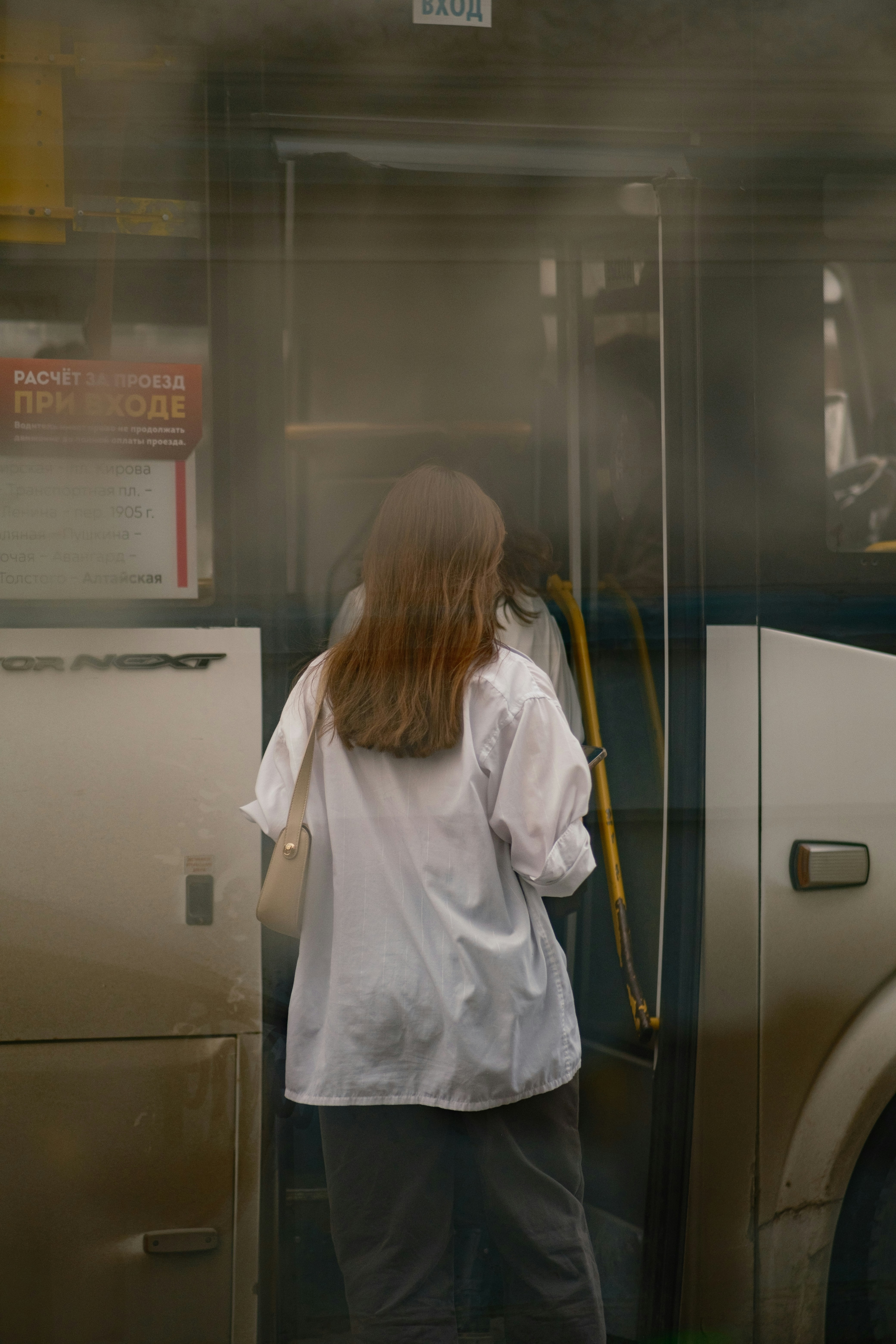 Backlit Traveler at a City Bus Stop