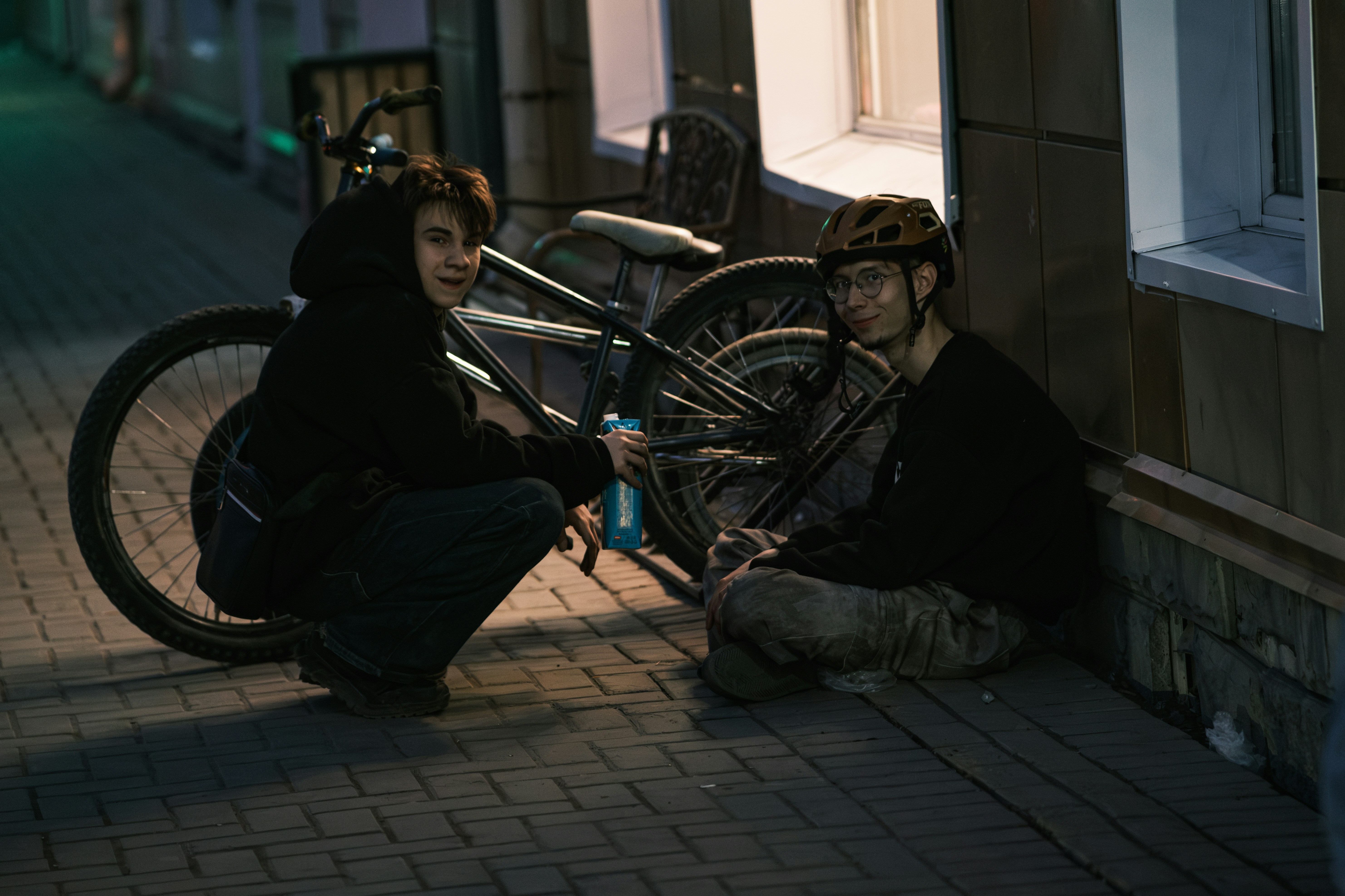 Night Ride Break: Two Bikers Rest by a Street-Quiet Wall
