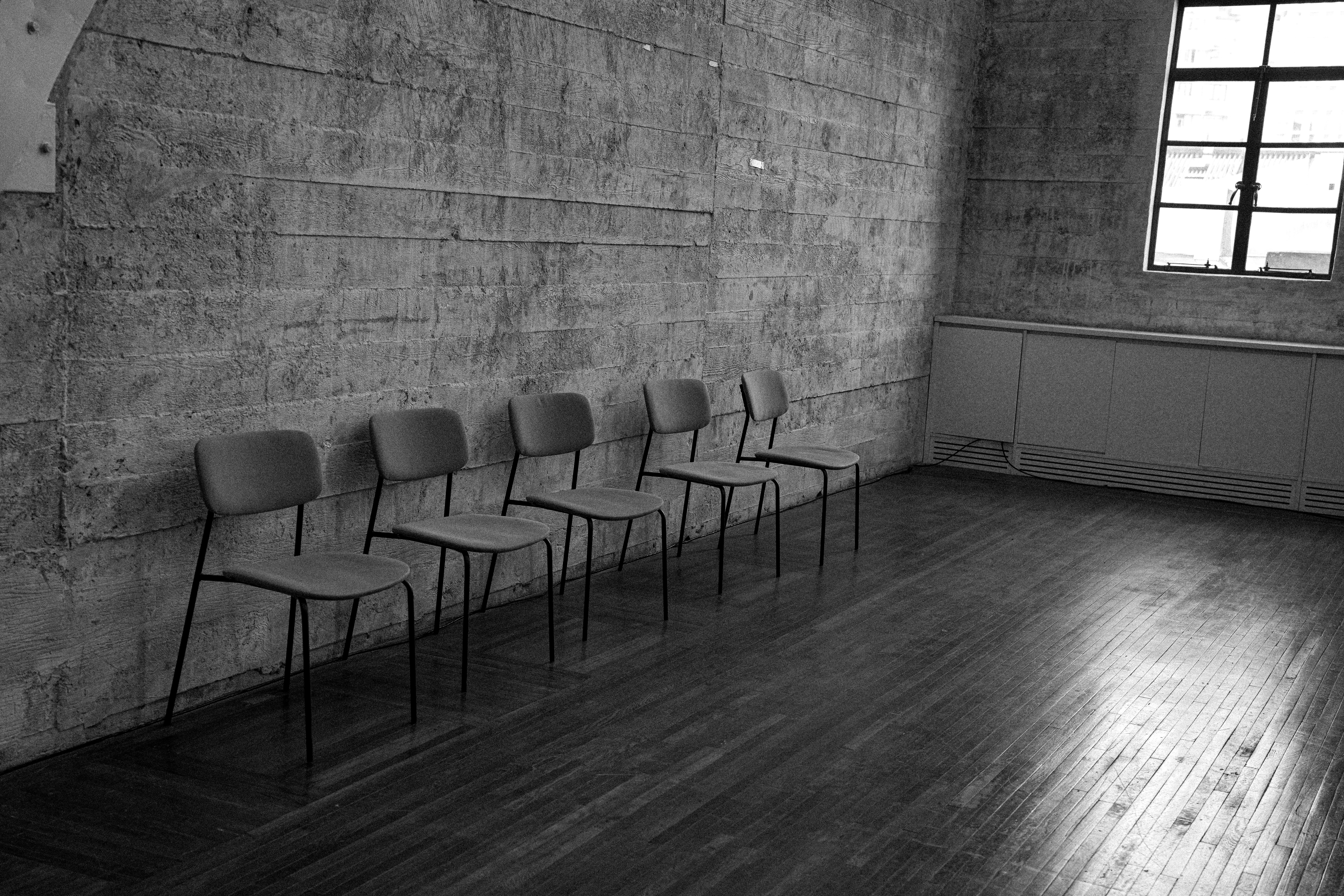 Rows of Chairs Quietly Line a Weathered Studio