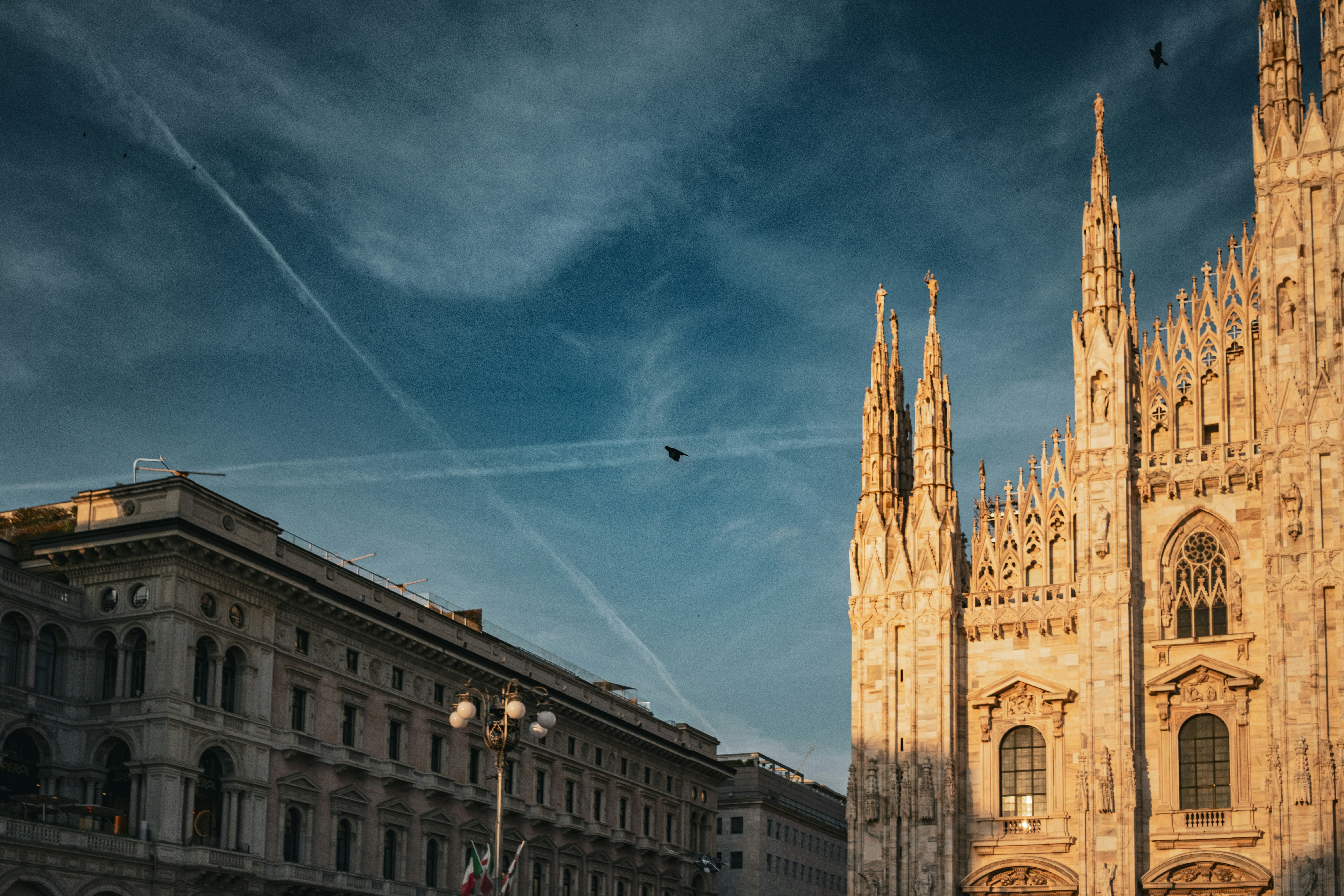 Gothic Facade Beneath a Sky of Contrails