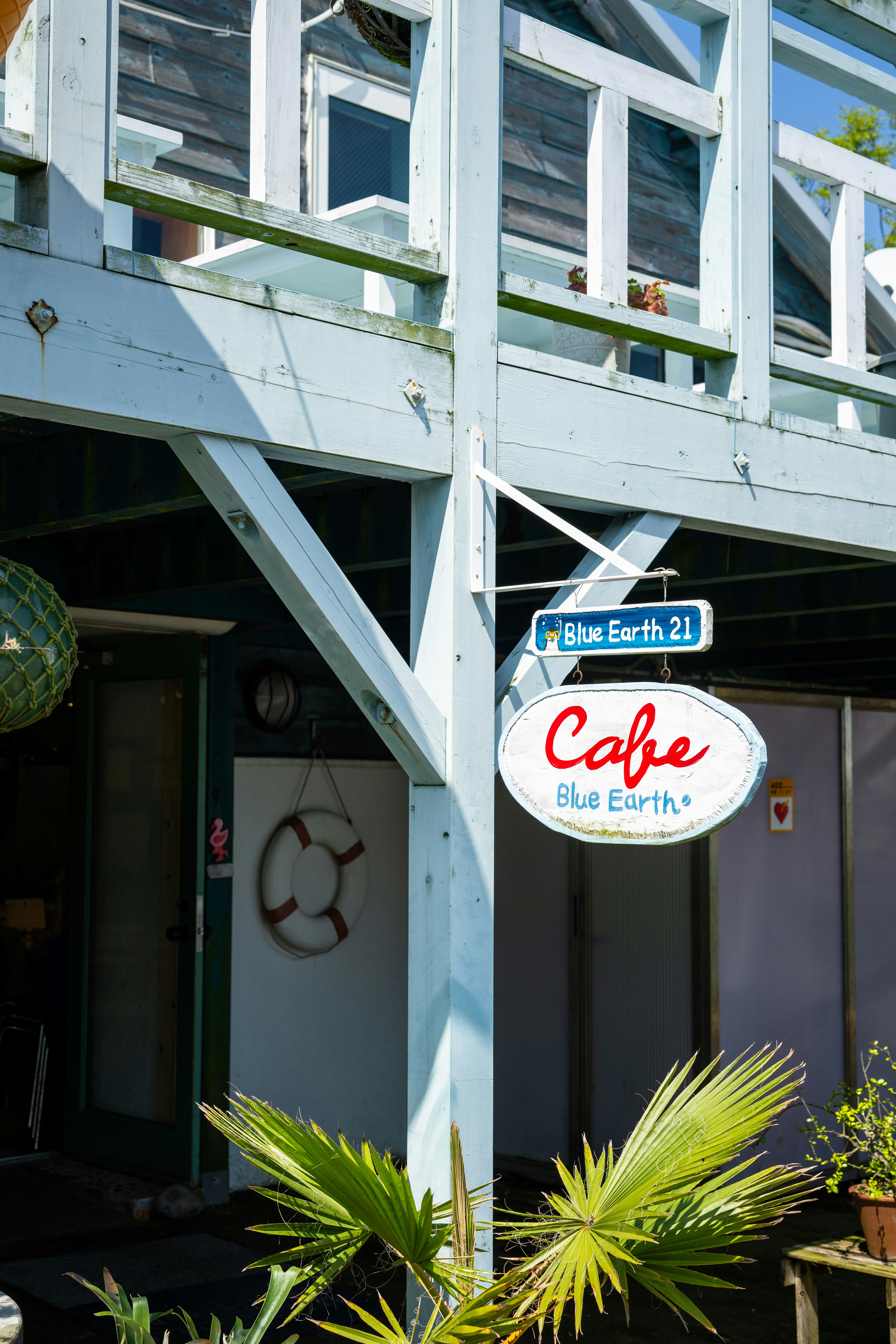 Blue Earth Café Sign Nestled Under a Weathered Boardwalk