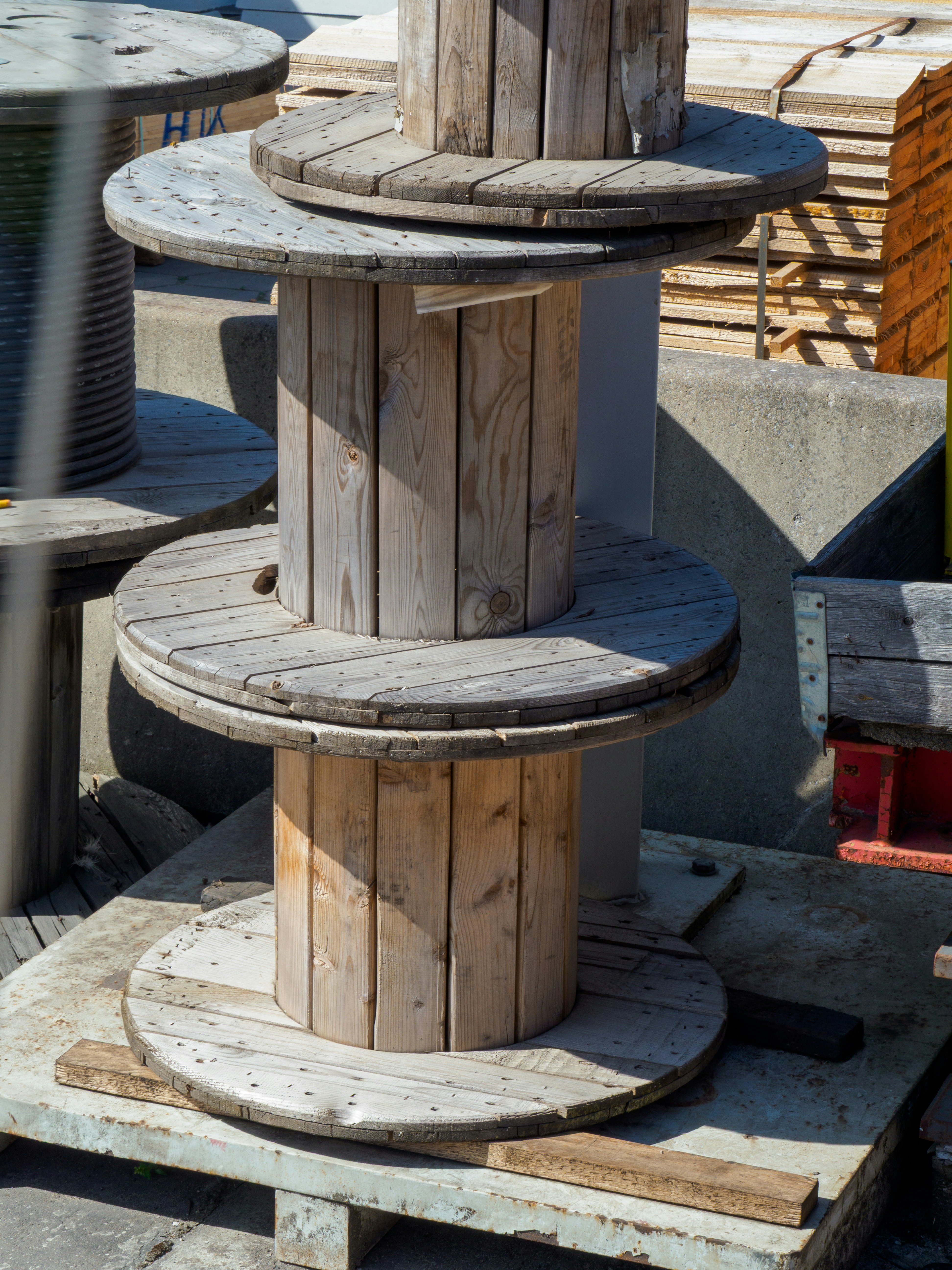 Weathered wooden spools stacked along a harbor edge