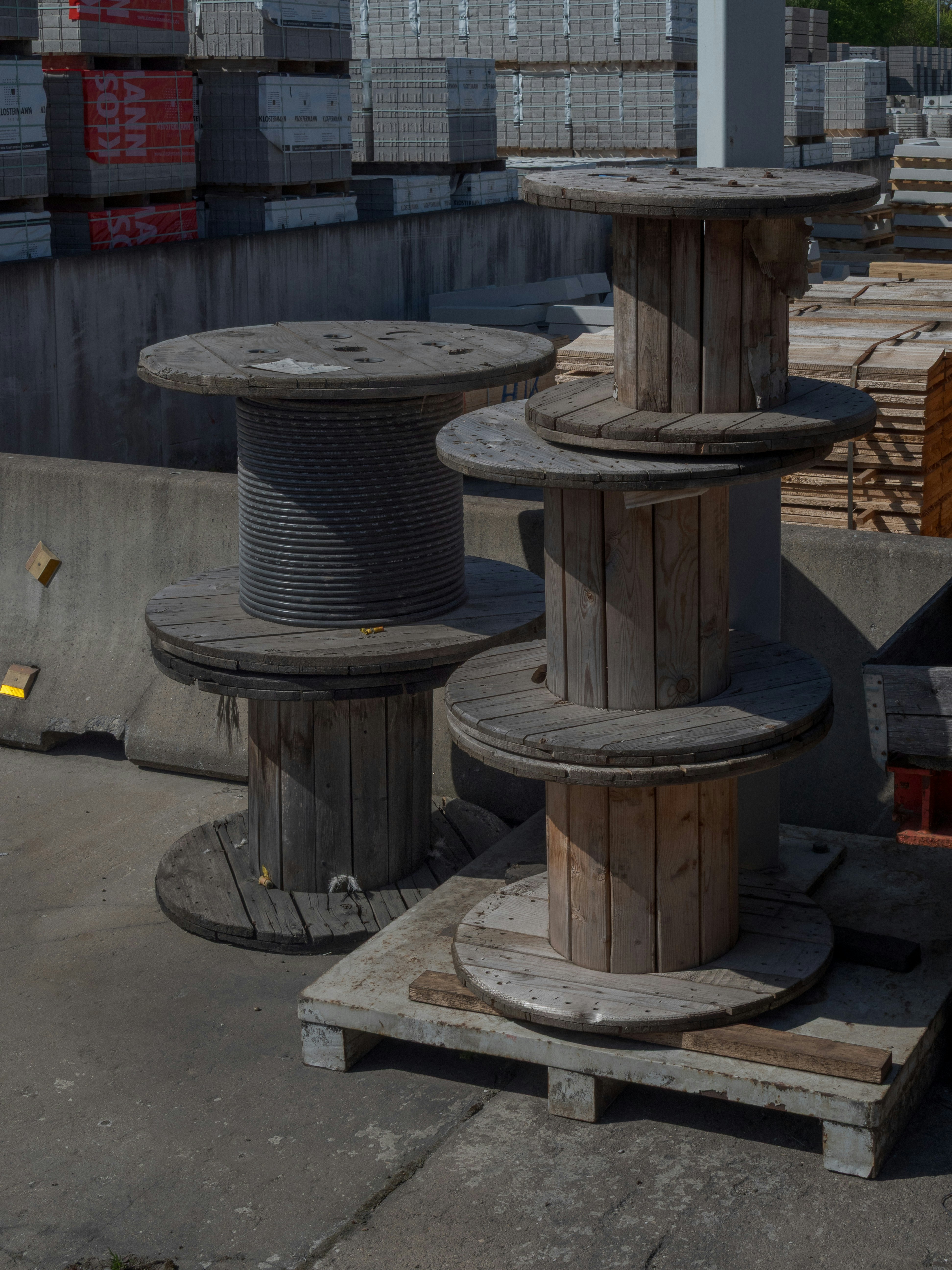 Weathered spools at the edge of a lumber yard