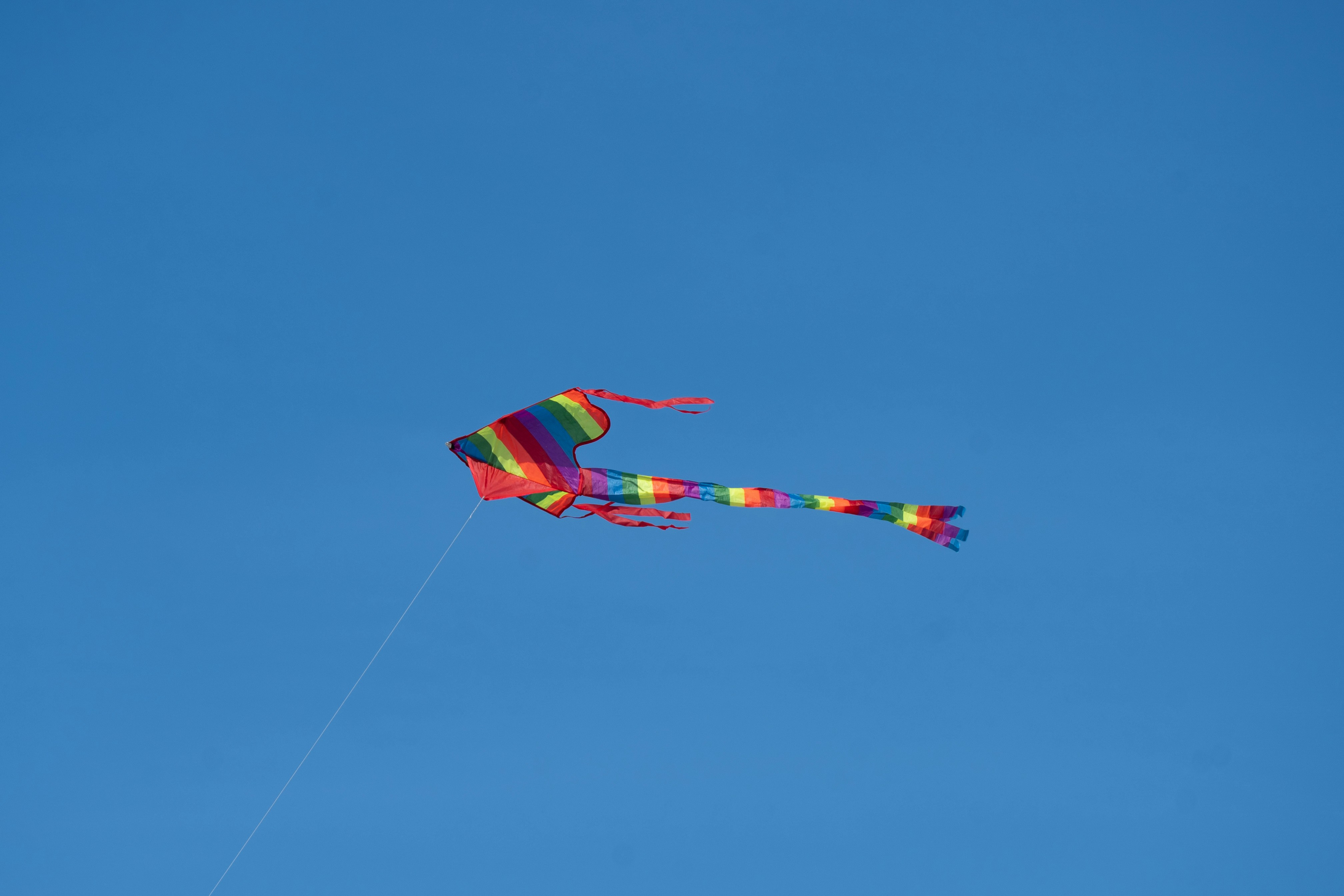 Rainbow Kite Soaring Against Blue: A Crisp Day Flight