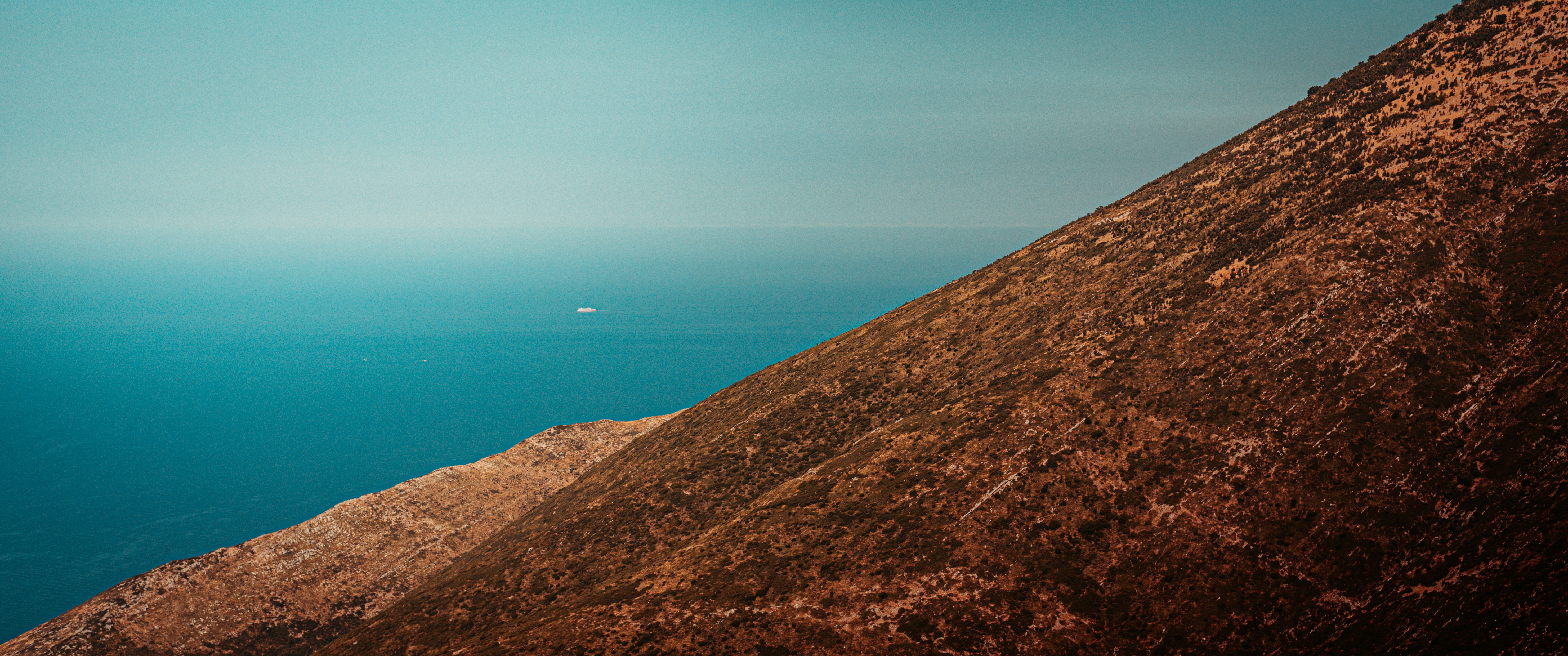 Sun-sculpted Slope Falling Toward a Distant Blue Sea