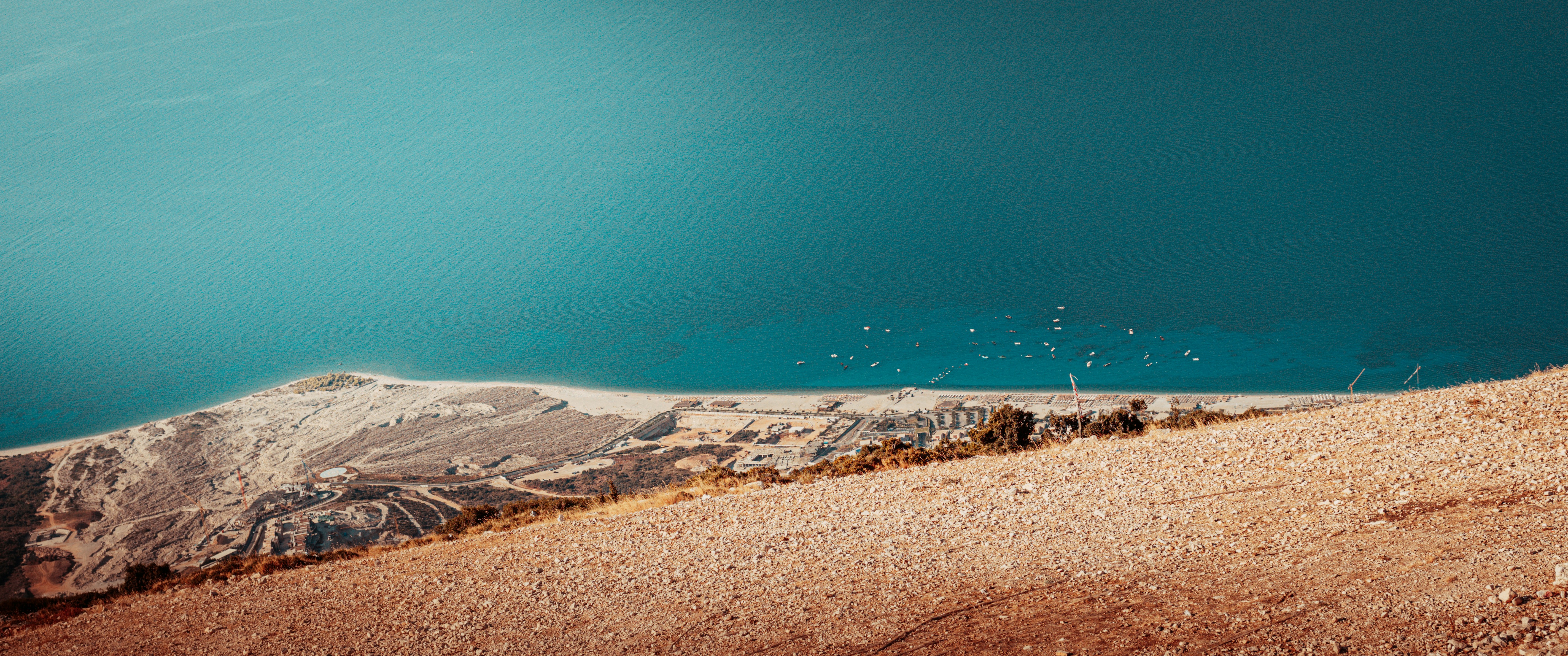 Deserted shoreline on a sunlit slope meeting the sea