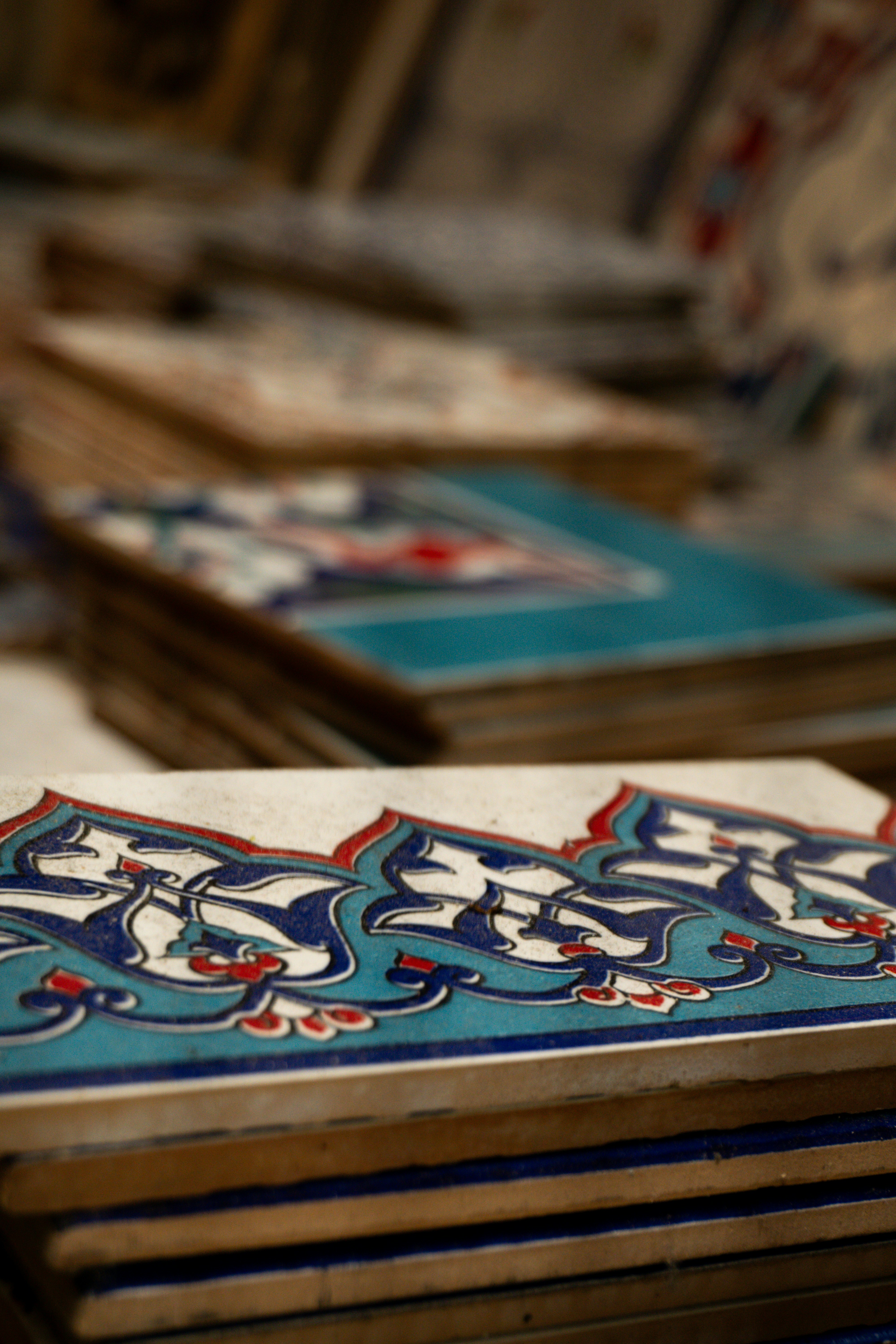Rolled Tiles in a Quiet Workshop: Decorative Tiles Stacked in Soft Focus