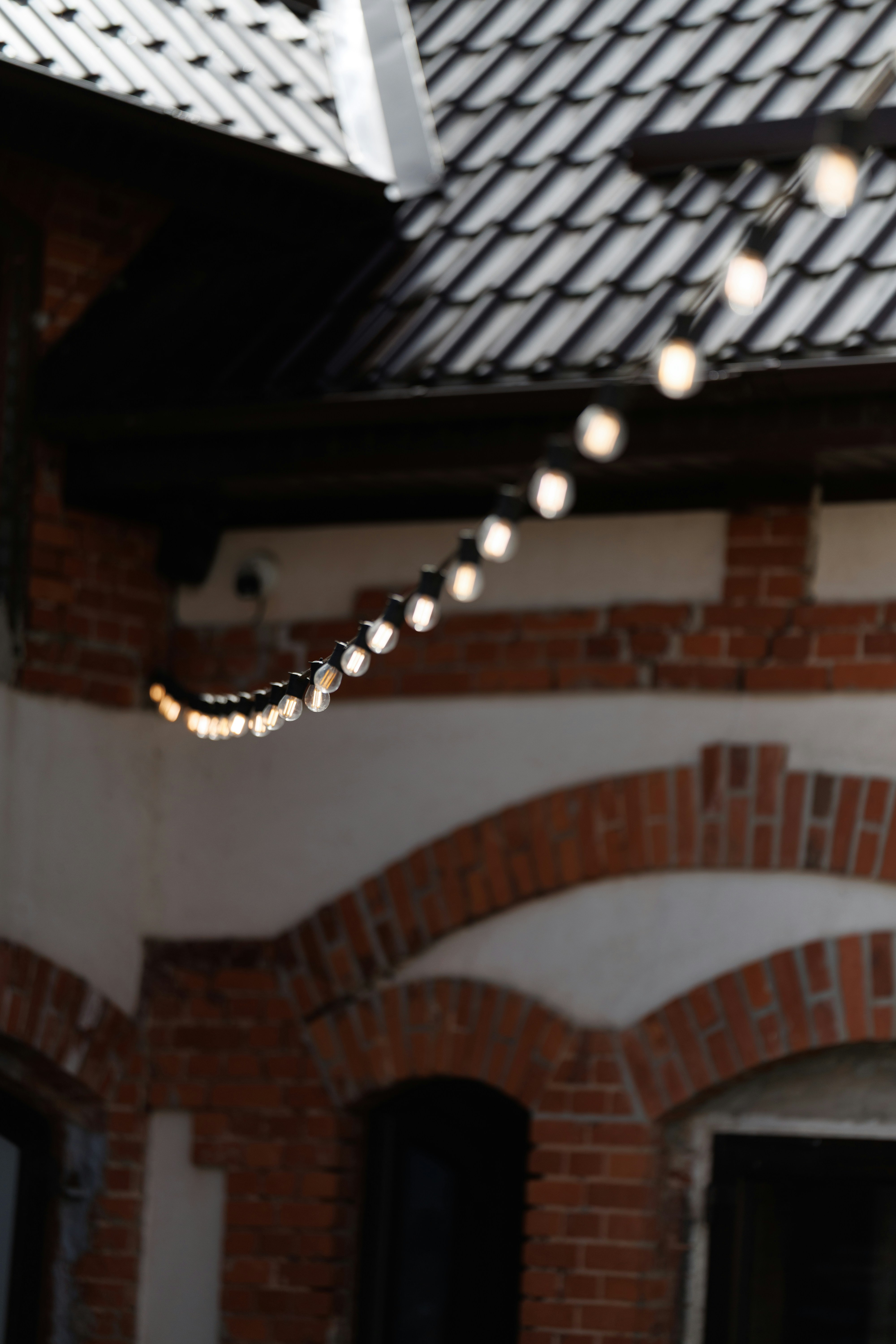 String of Warm Lights Against Bricked Architecture