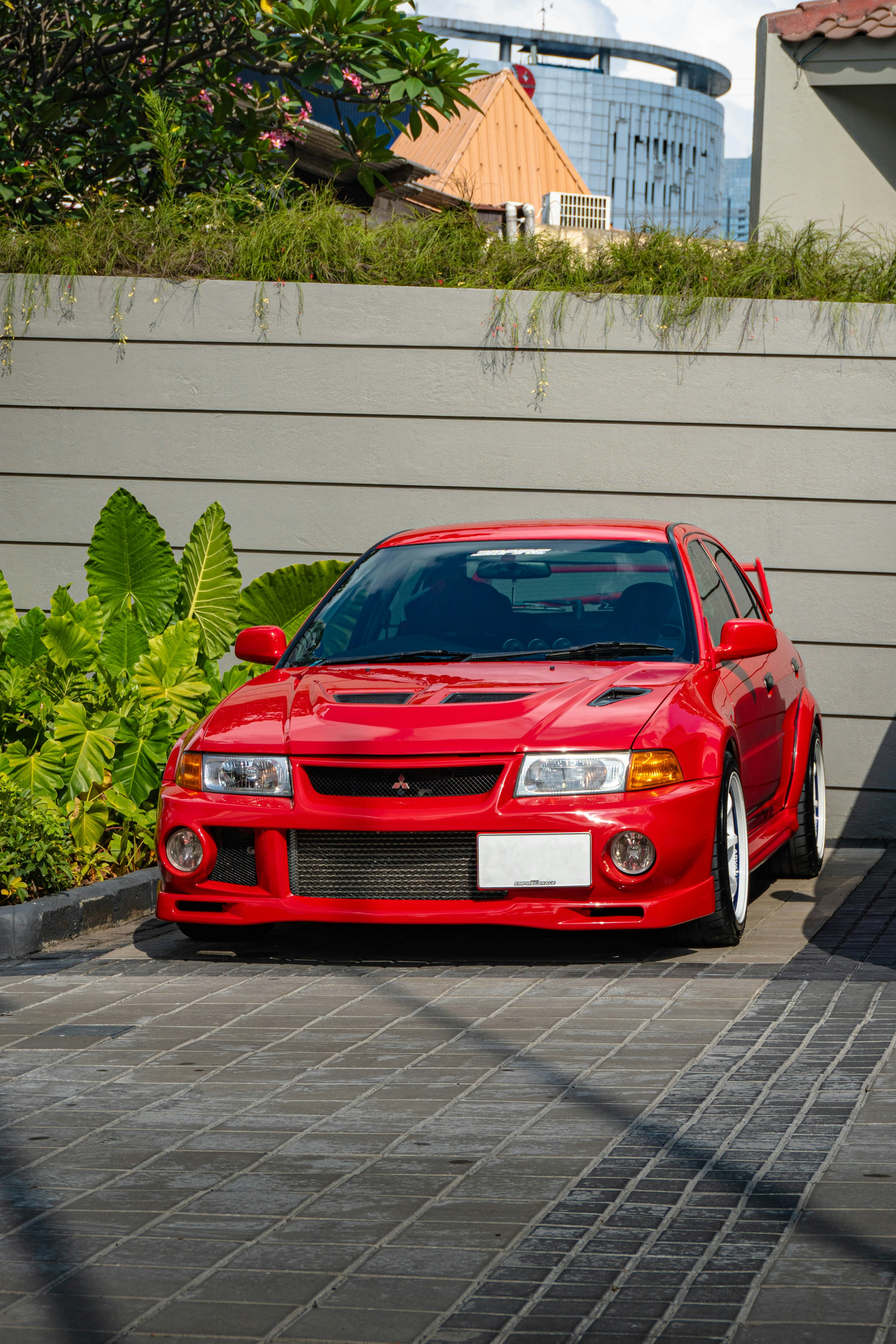 Crimson Roadster Anchored by a Modern Urban Backdrop