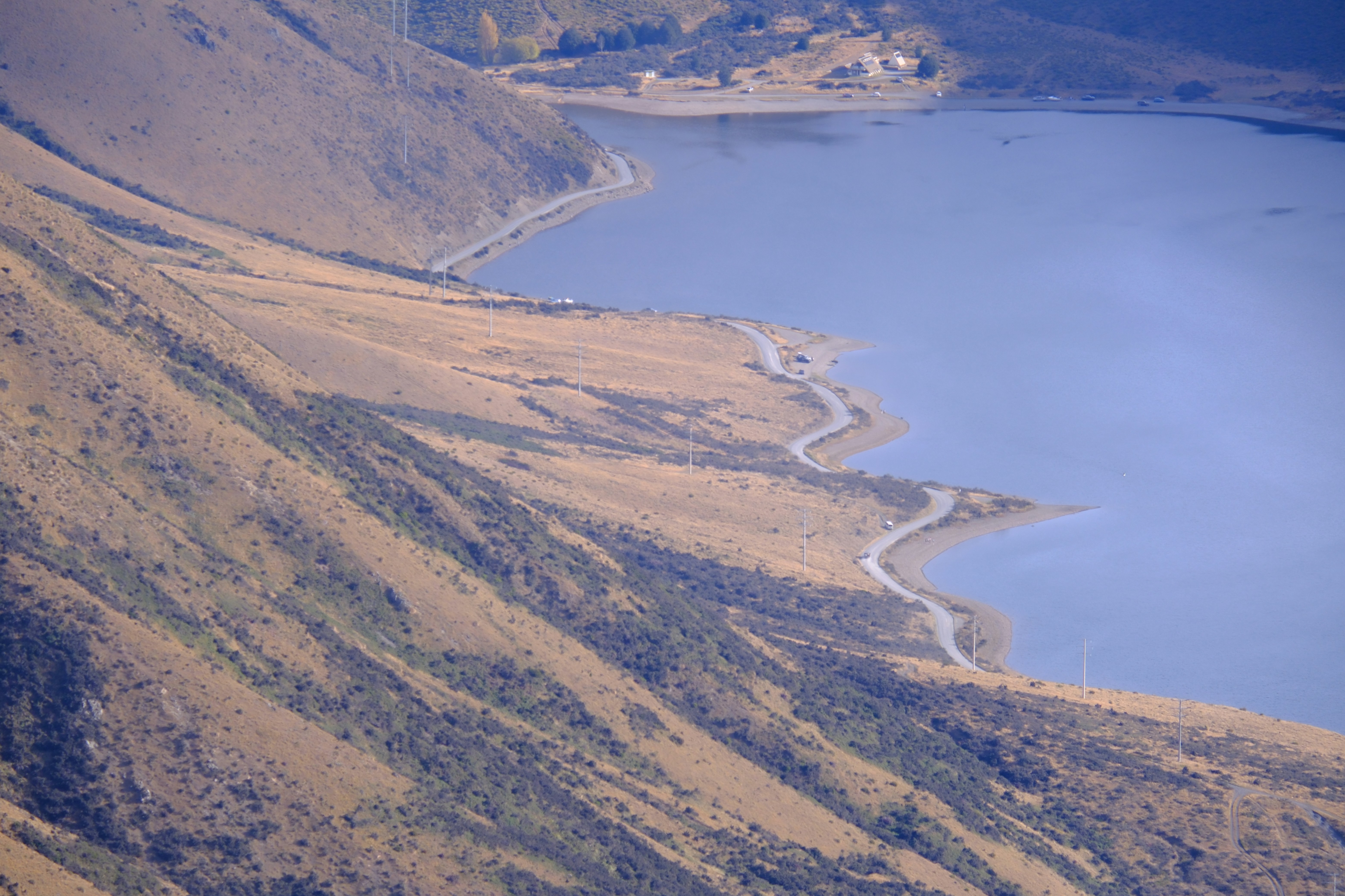 Serpentine shoreline cutting through sunlit hillside