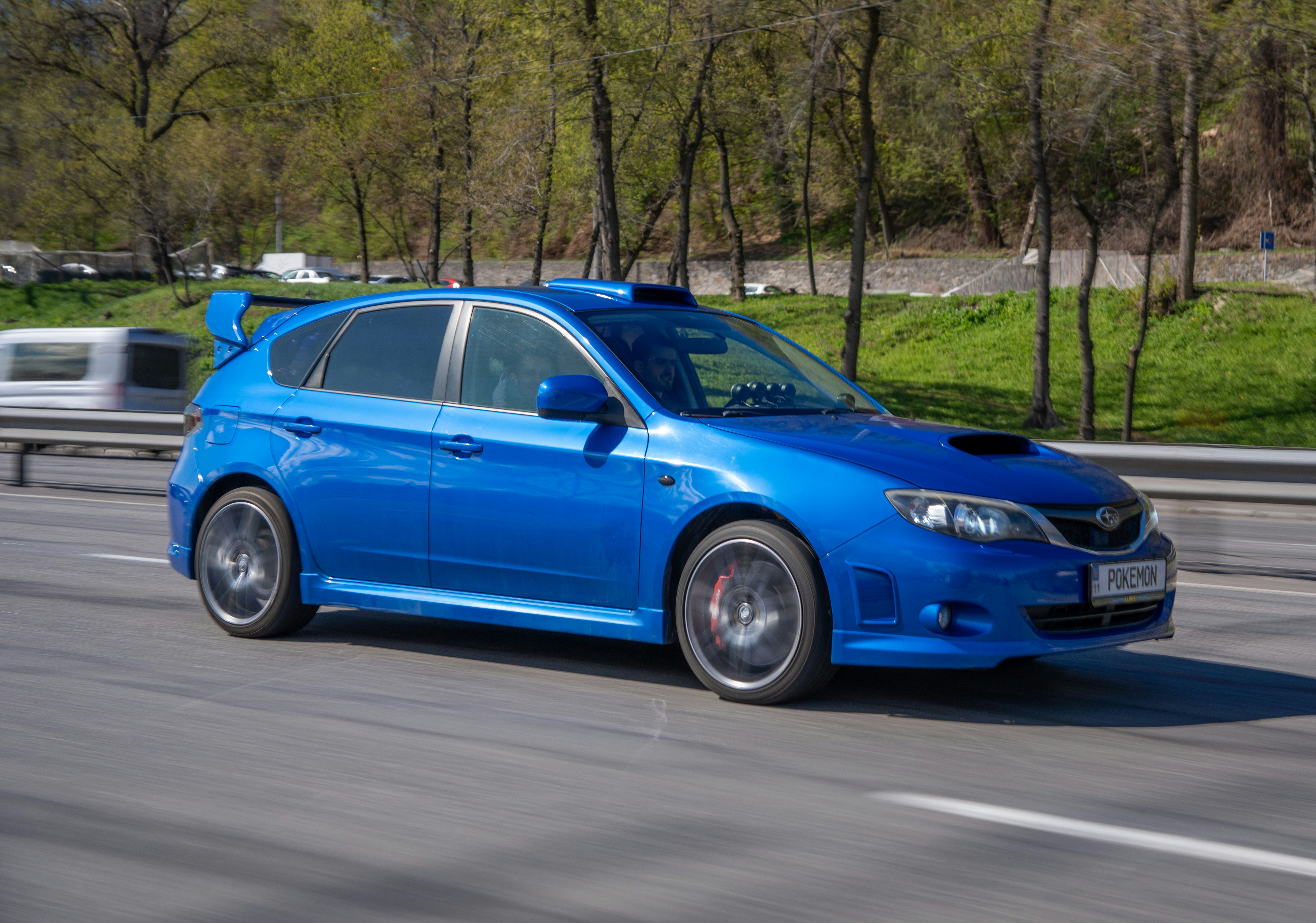 Blue Sport Hatch in Motion: Street Drift on a Sunlit Highway