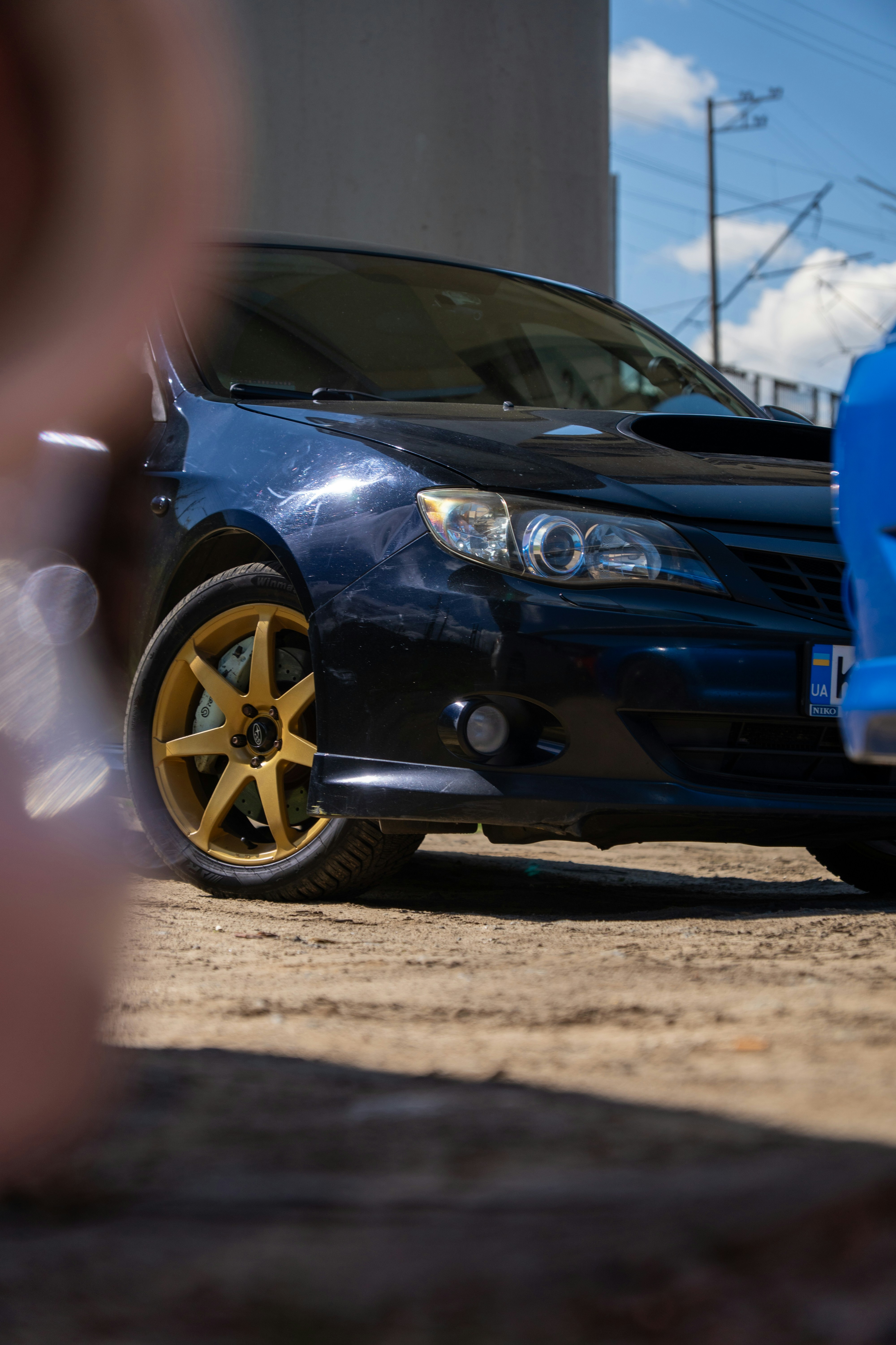 Golden Wheel Emblem: A Dark Blue Sedan with Bright Alloy Rims in Focus