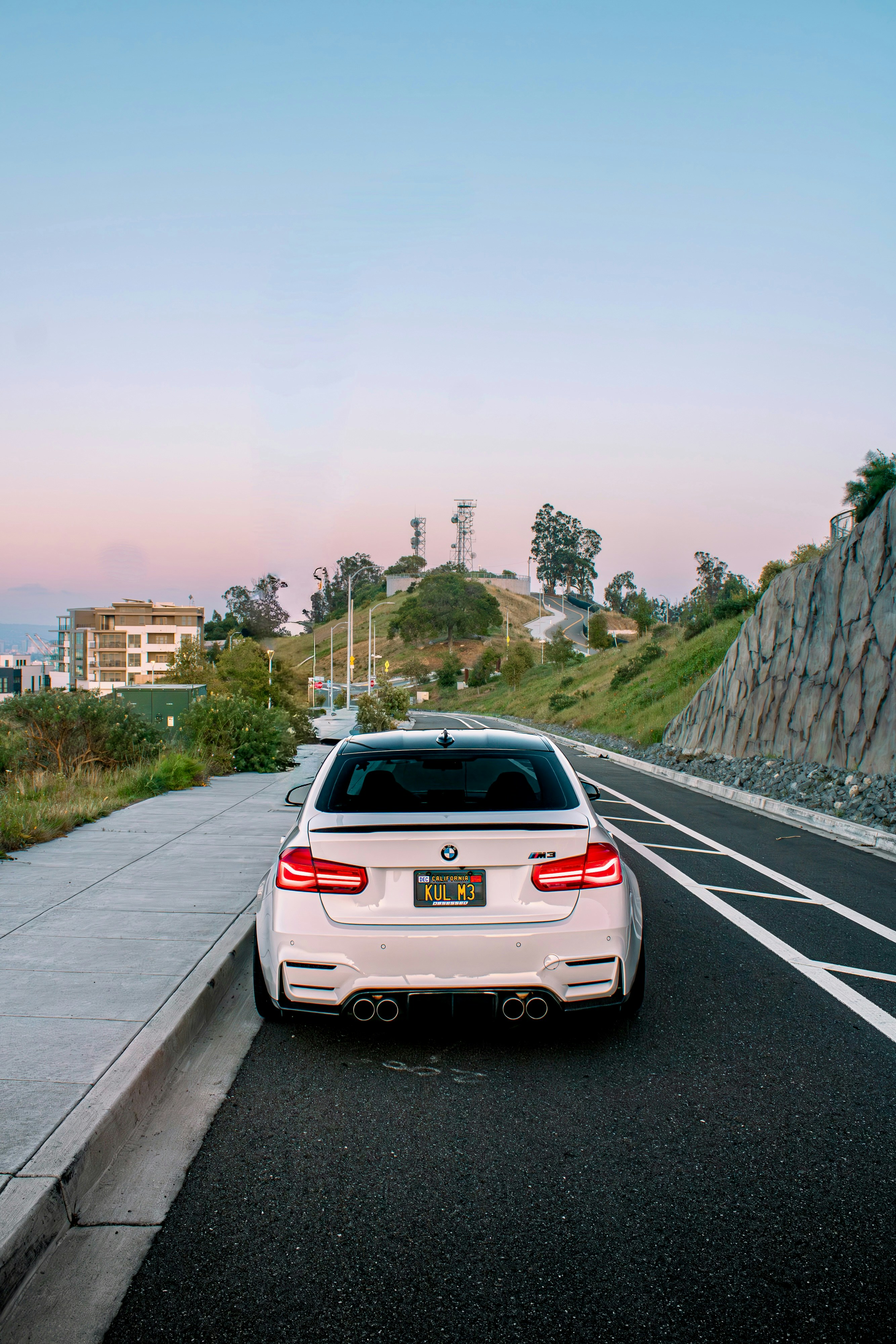 Rear-View Prelude: A White BMW Anchors a Quiet Coastal Road